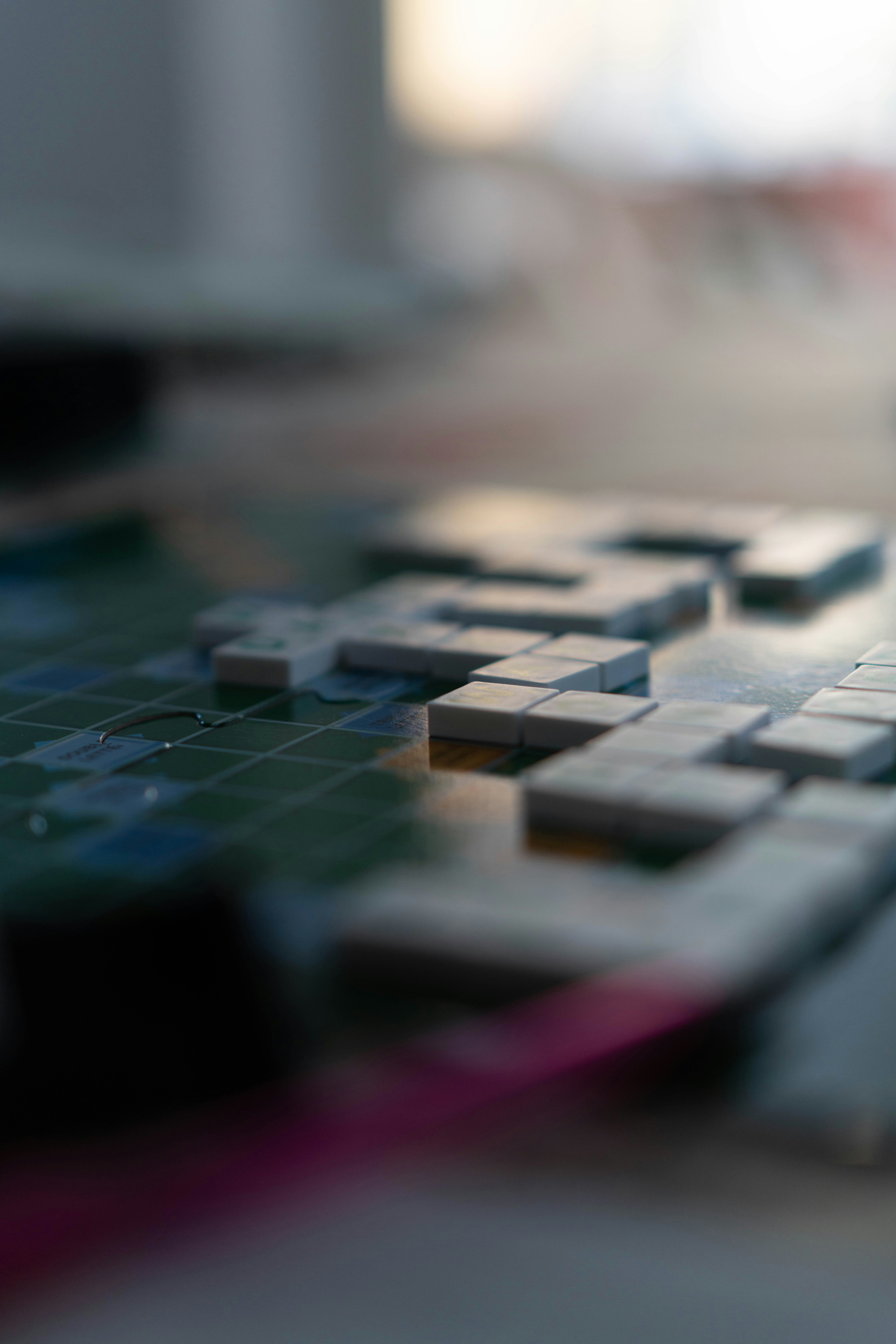 Close-up of a Scrabble board with tiles arranged in a strategic layout, showcasing the game’s intricate design and vibrant colors.