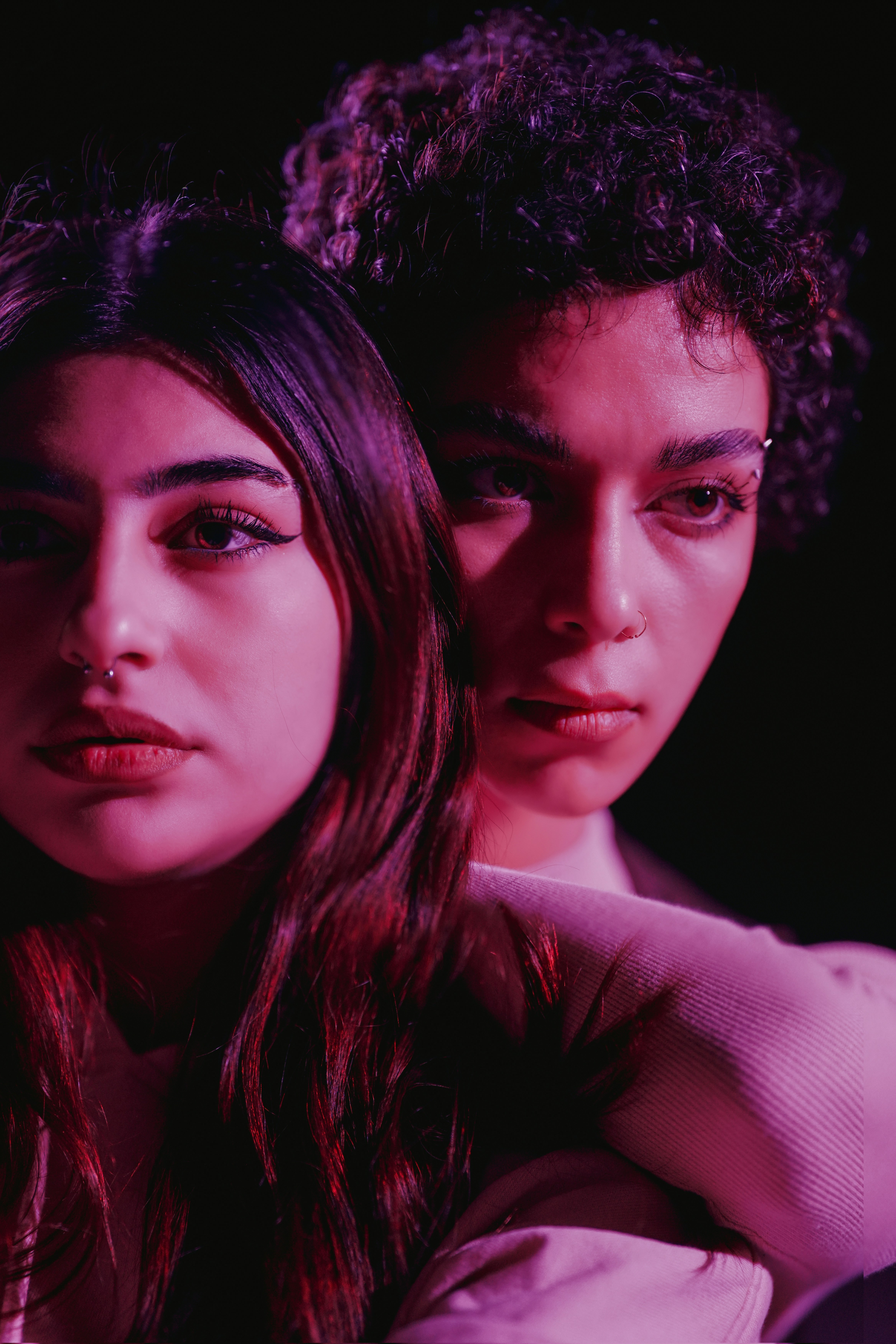 Two people are embracing in the dim, pink light. photo – Free Woman ...