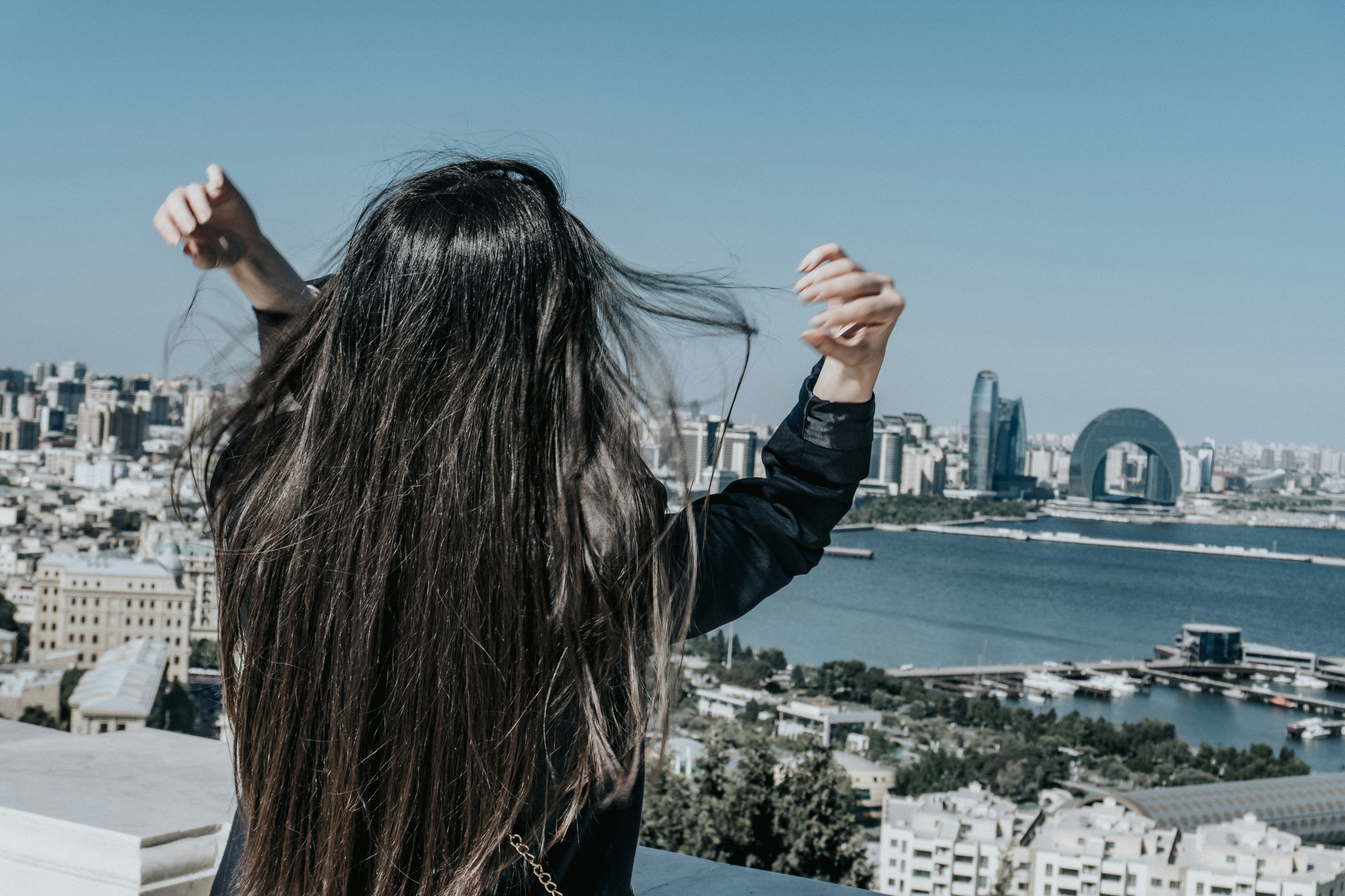 Overlooking the City: A Girl with Windswept Hair Embraces the Horizon