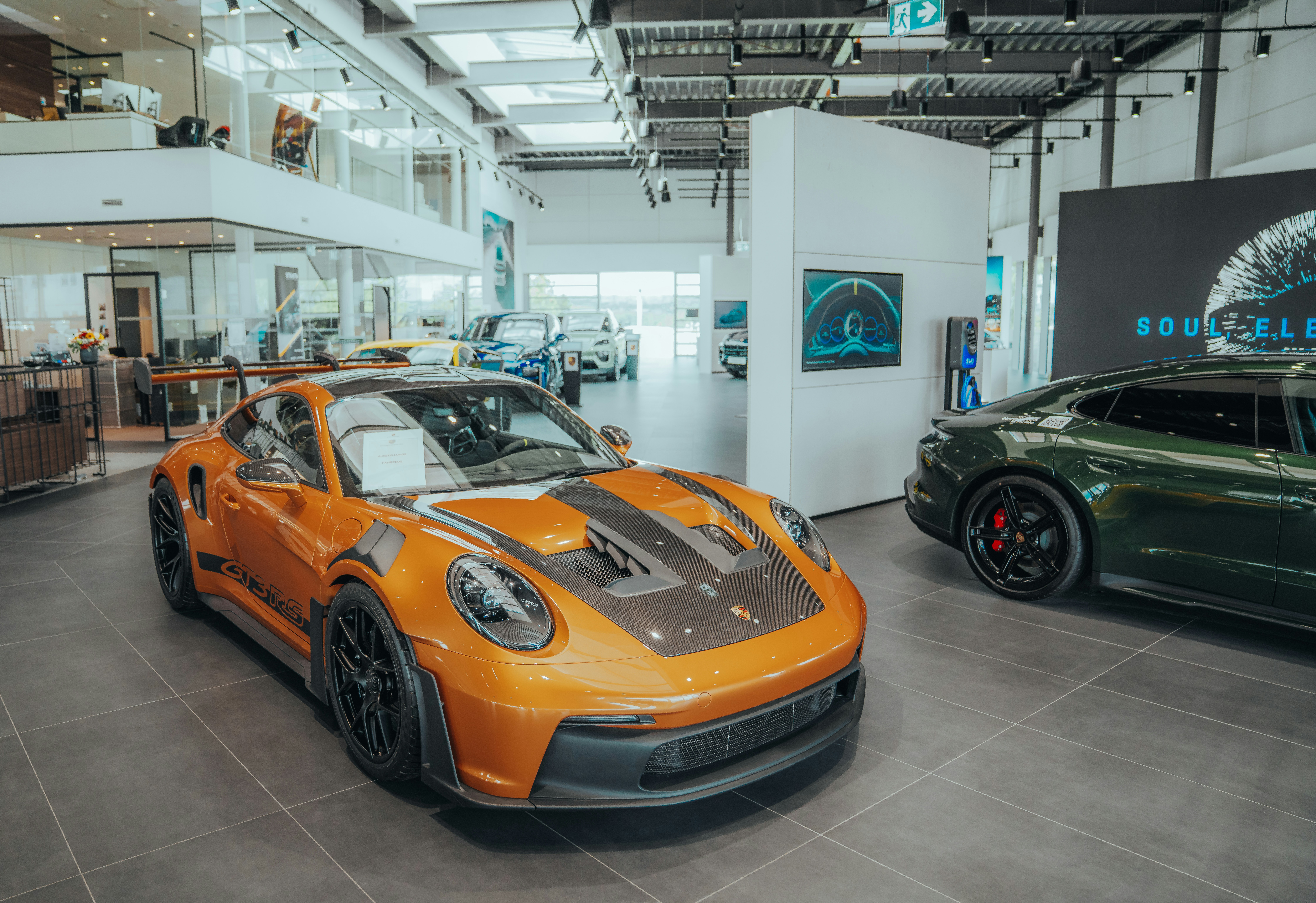 A new porsche and other cars in showroom. photo – Free Car Image on ...