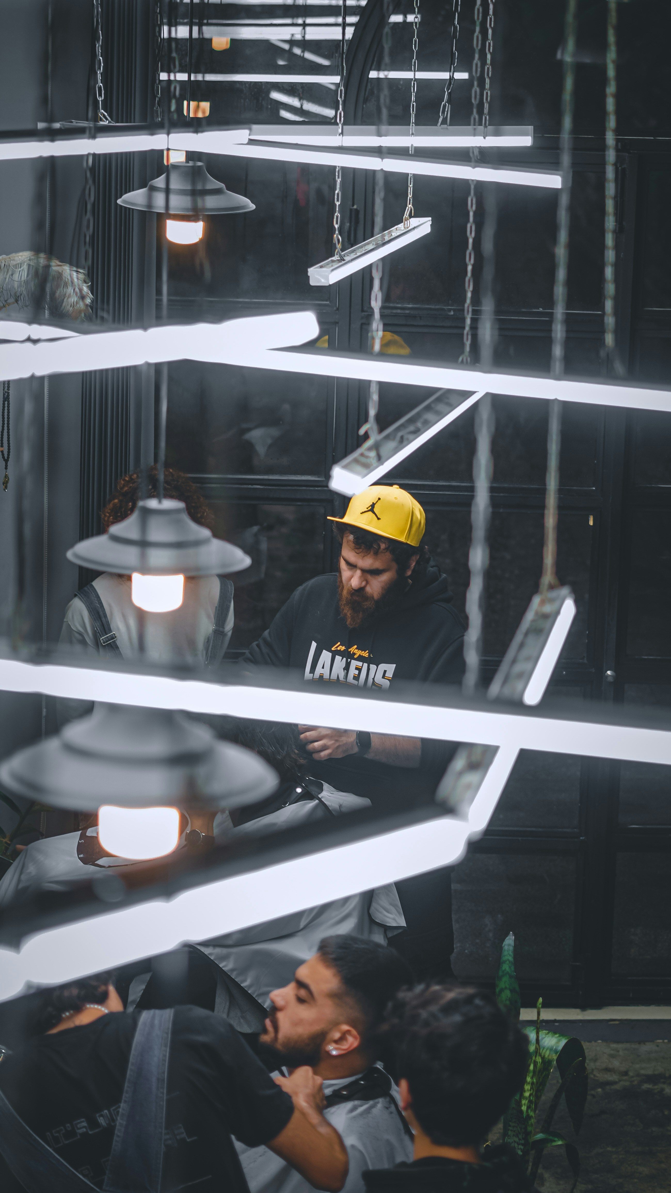 Neon Tubes and a Yellow-Capped Barber: A Quiet Moment Beneath Fractured Light