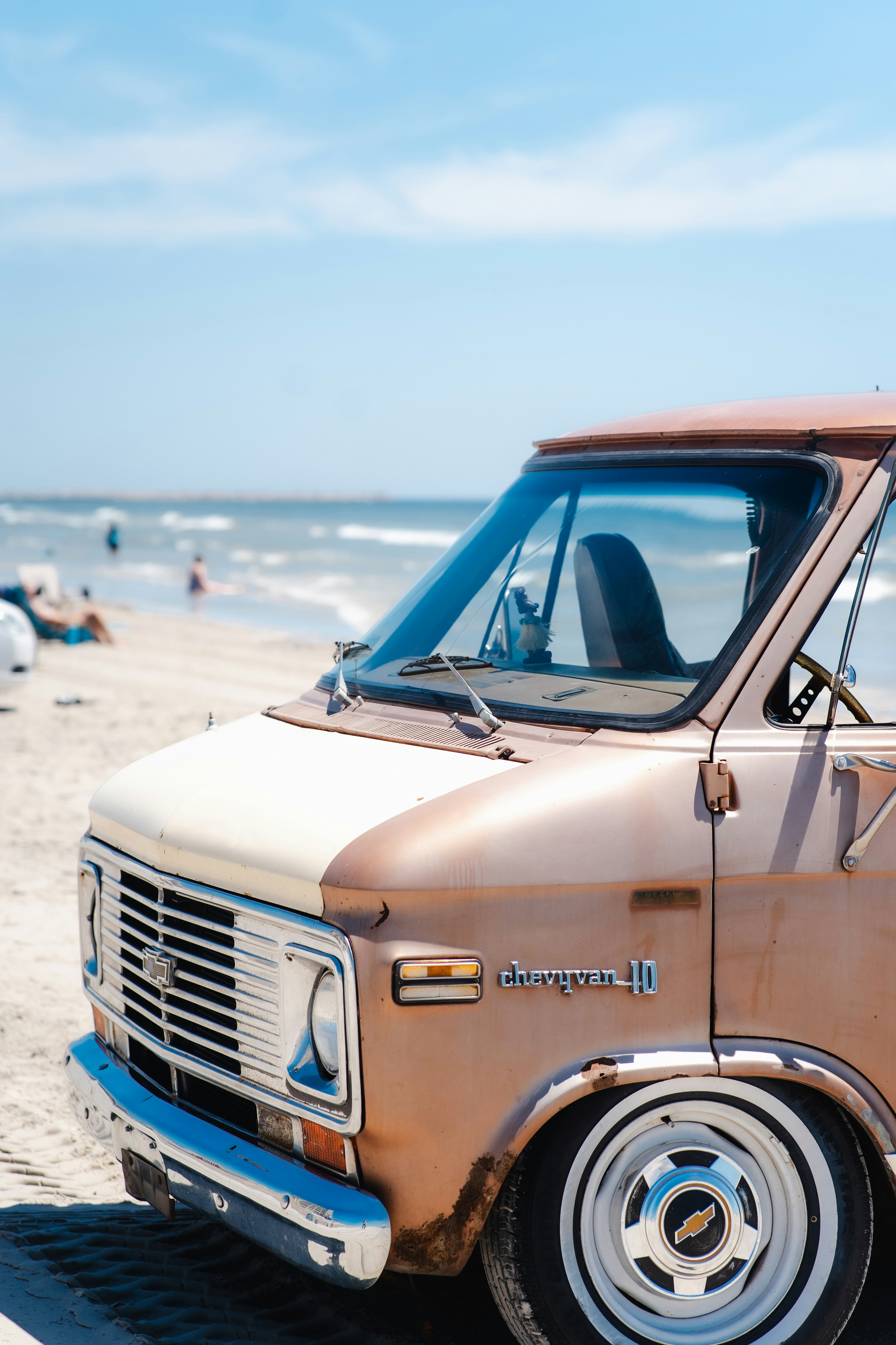 Sunlit Vintage: A Rusted Chevy Van resting on the shoreline