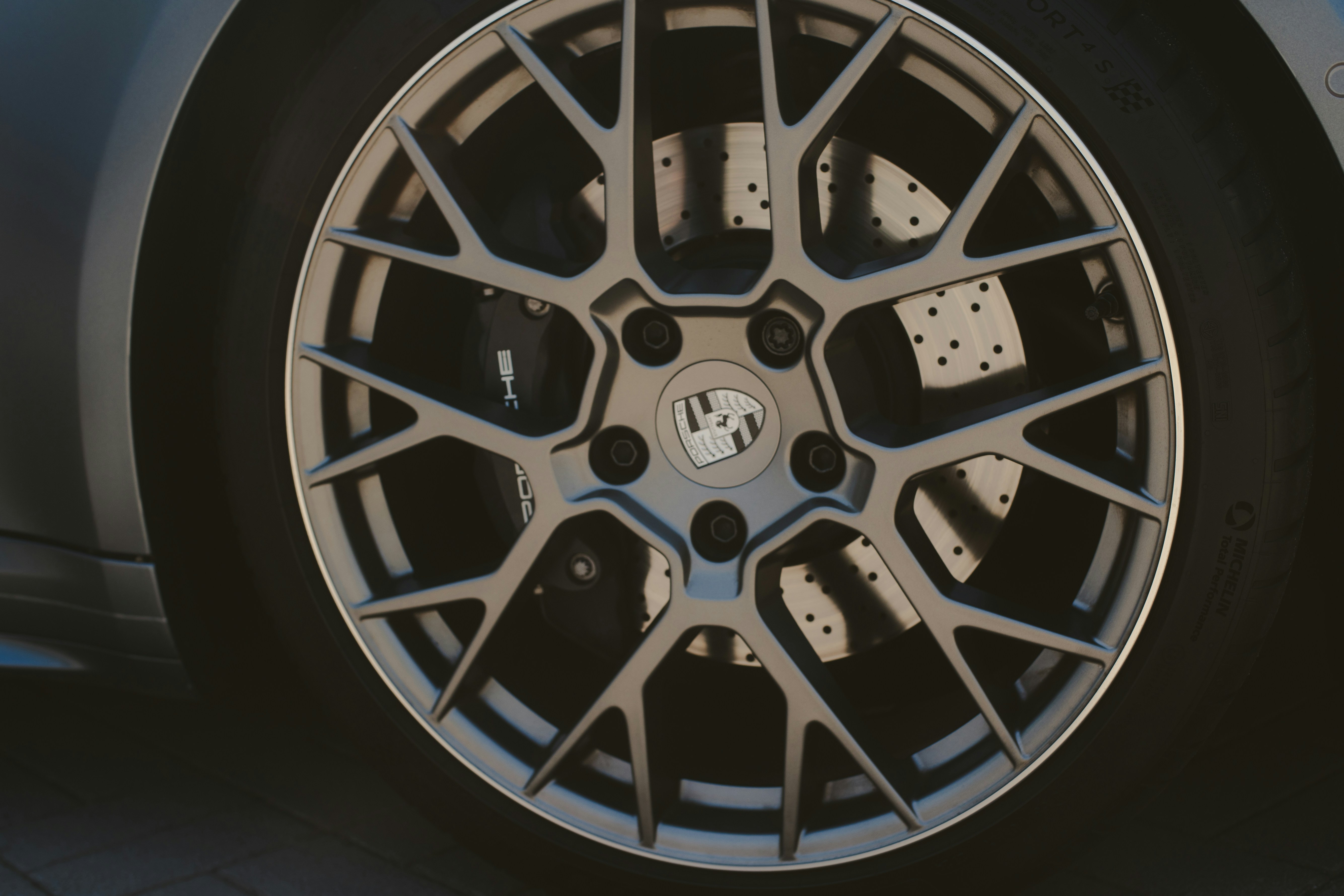Center of Velocity: Close-Up of a Porsche Wheel with Drilled Brakes and Crest