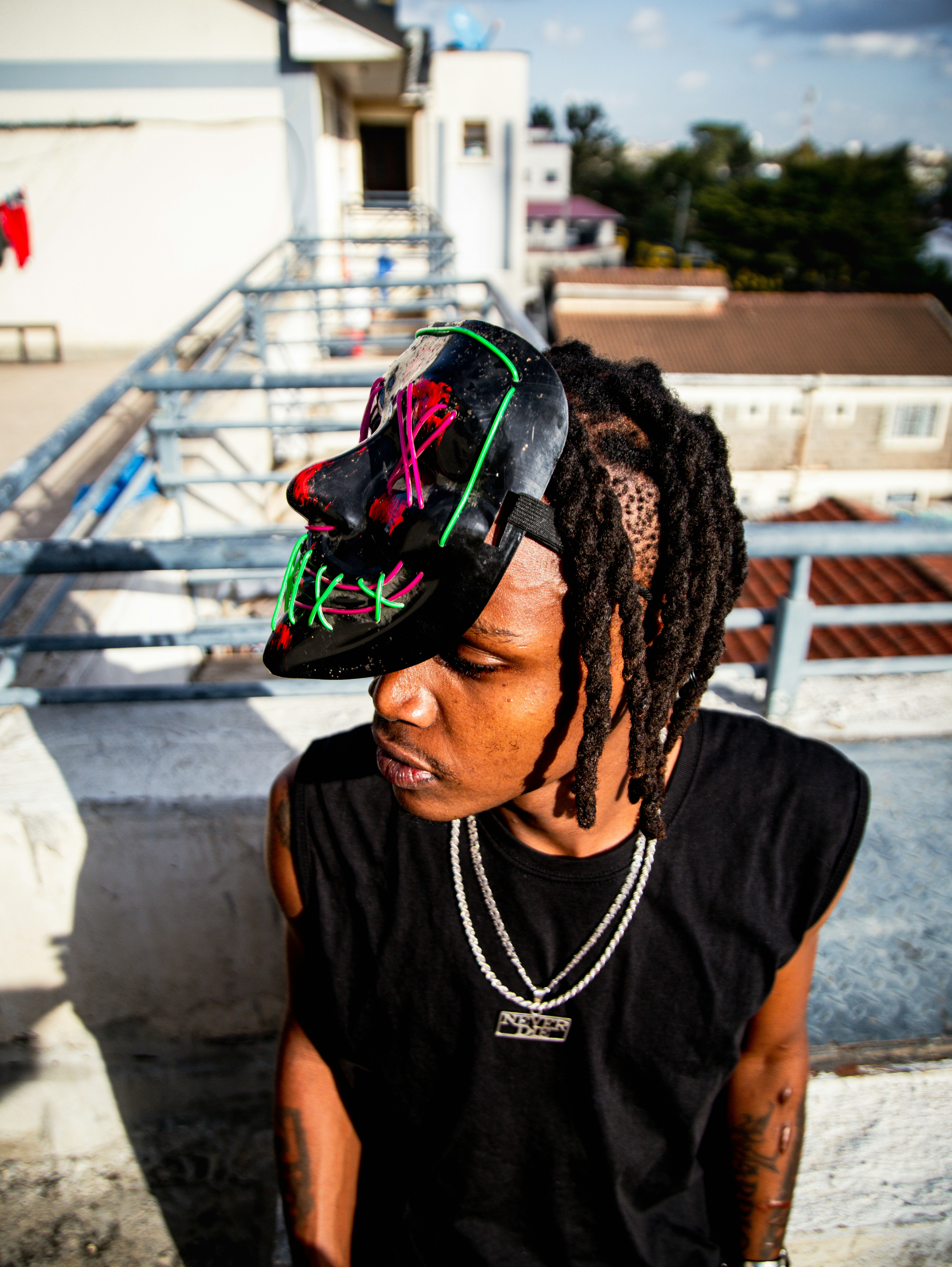 Neon-tipped cap and rooftop gaze