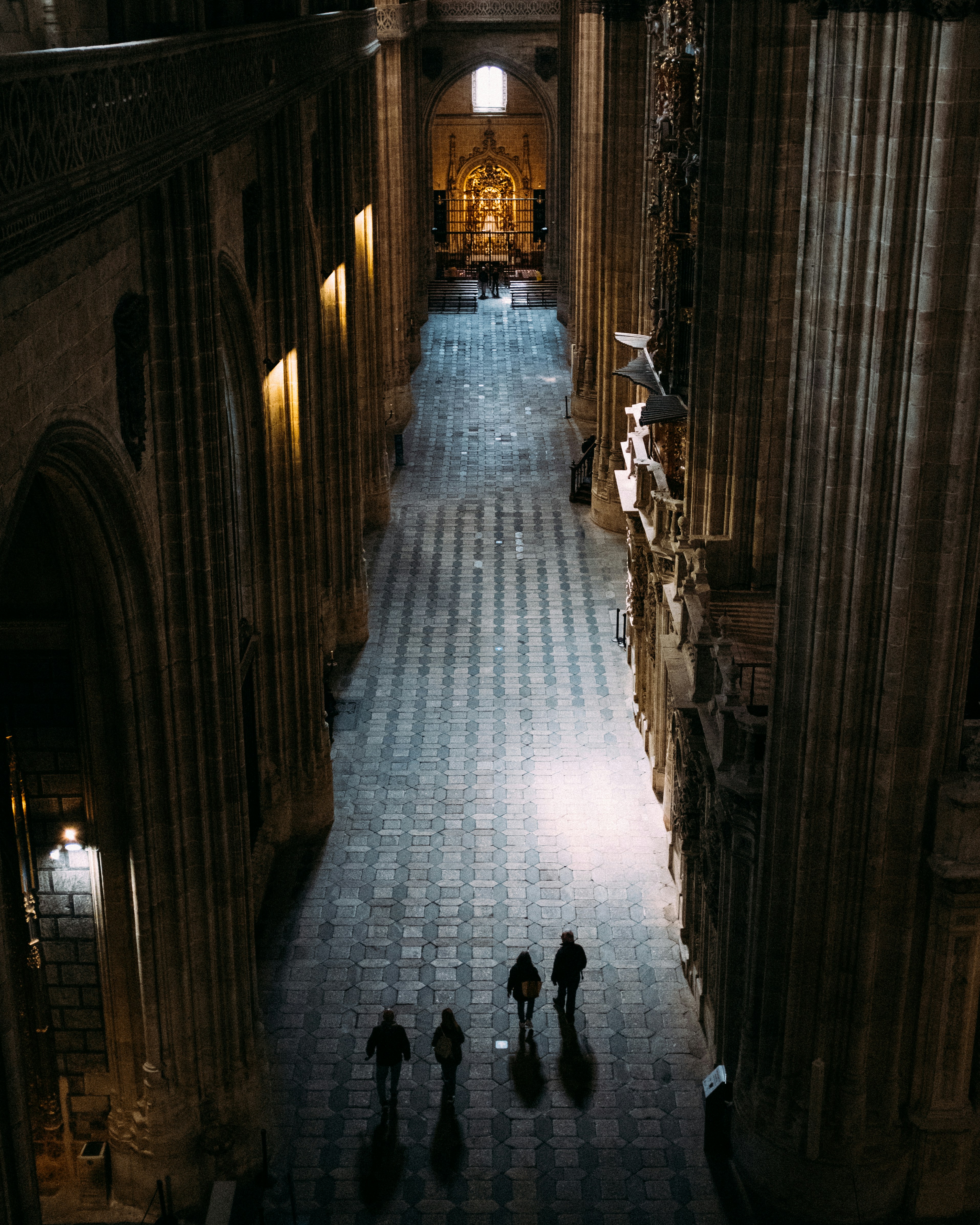 Five Silhouettes and a Distant Altar: A Cathedral Nave in Evening Light