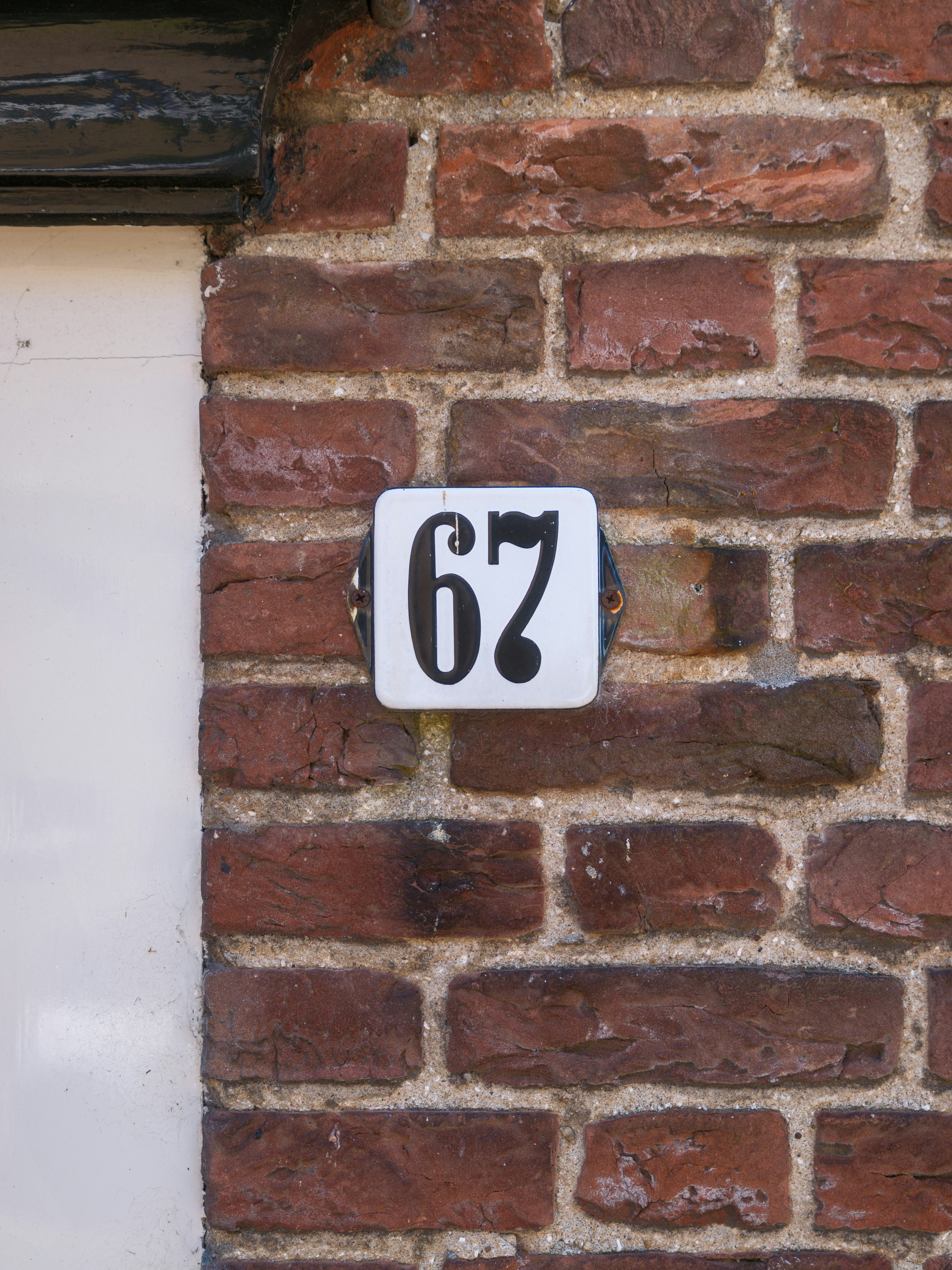 A house number, "67," is seen on a brick wall. photo – Free House Image ...