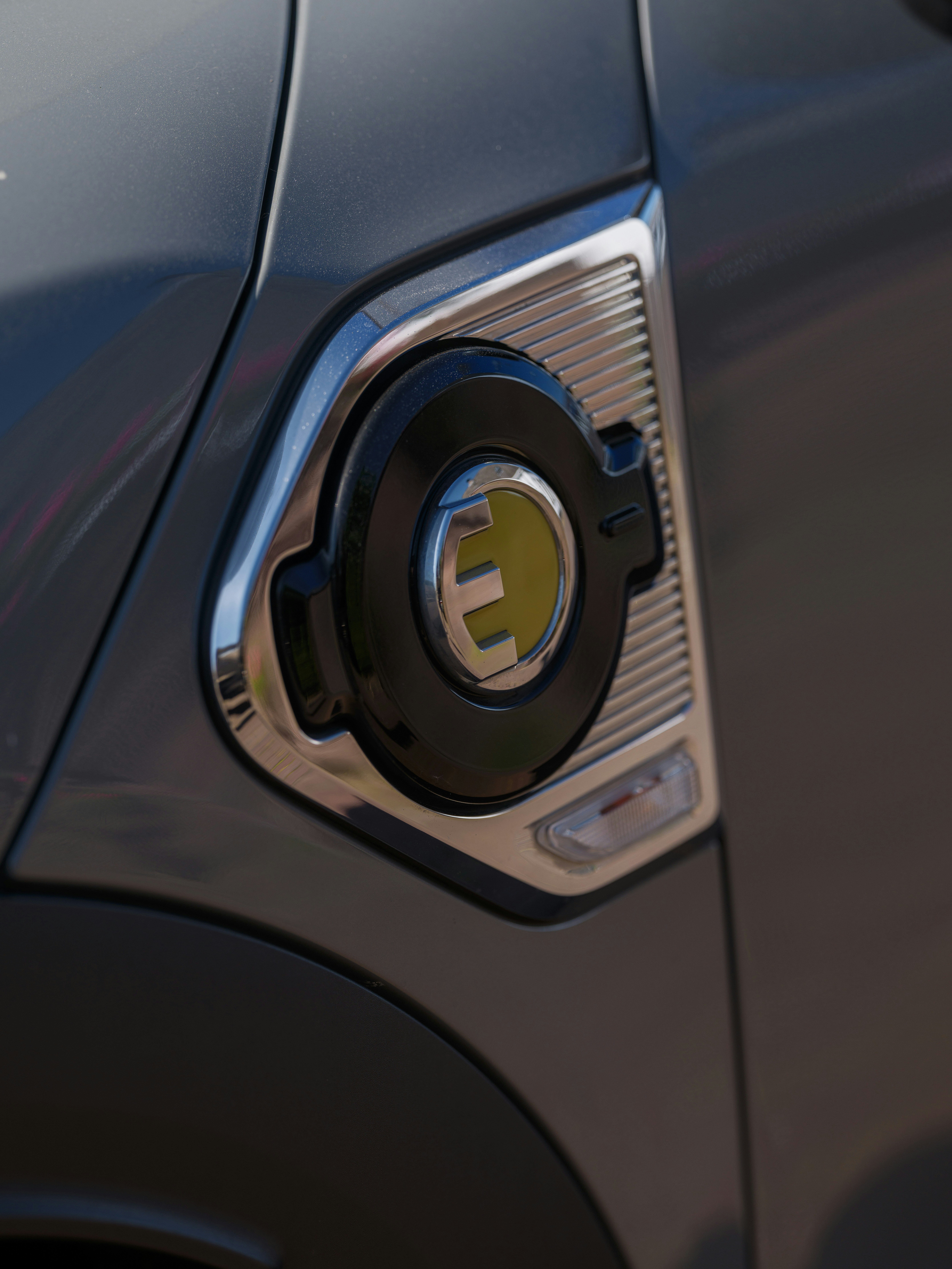 Precision Close-Up: Chrome-Rimmed Fuel Cap on a Deep Blue Car Panel