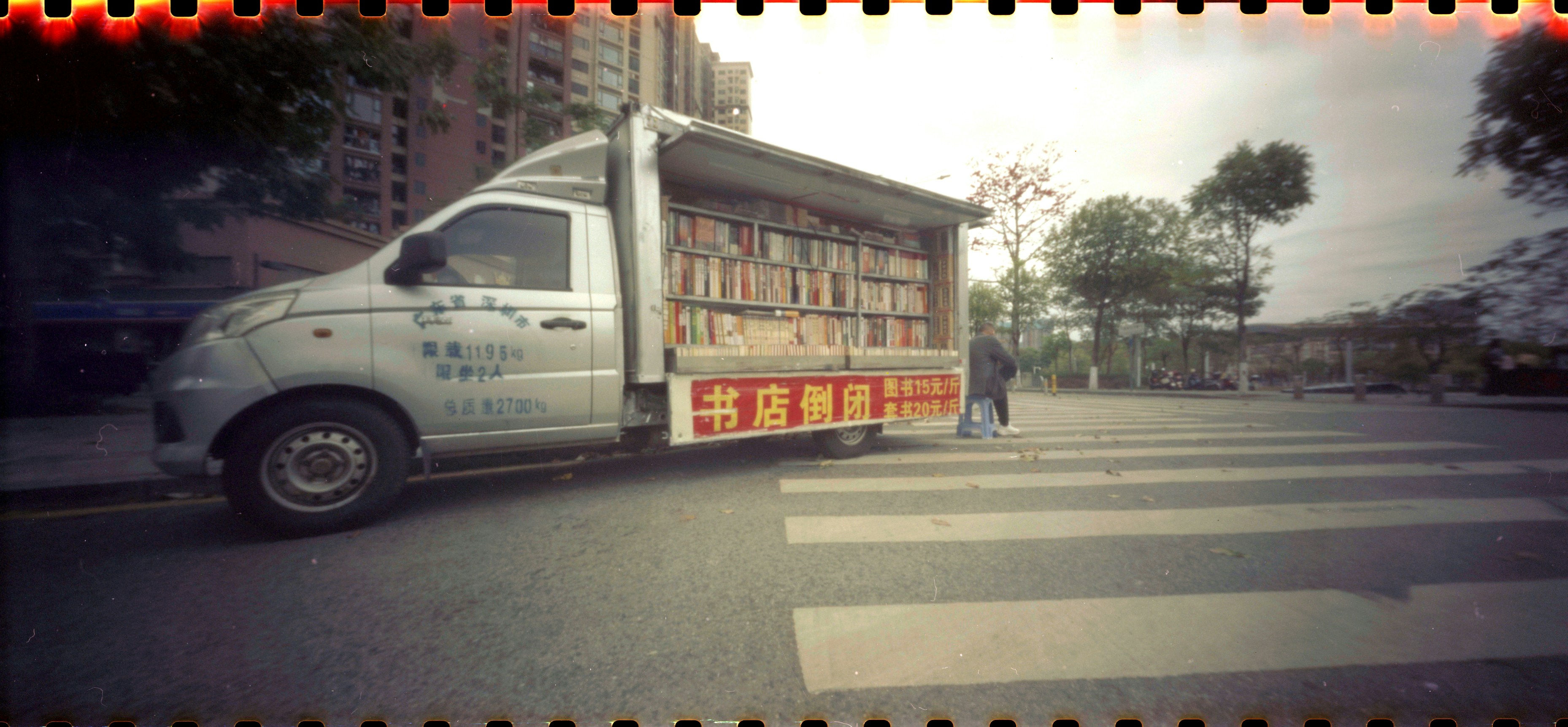 A parked truck at the intersection bore a striking banner: "Bookstore Closing Down—Everything Must Go!" The owner sat at the rear, eyes glued to his phone. It makes you wonder—why is everyone nowadays perpetually staring into their screens?