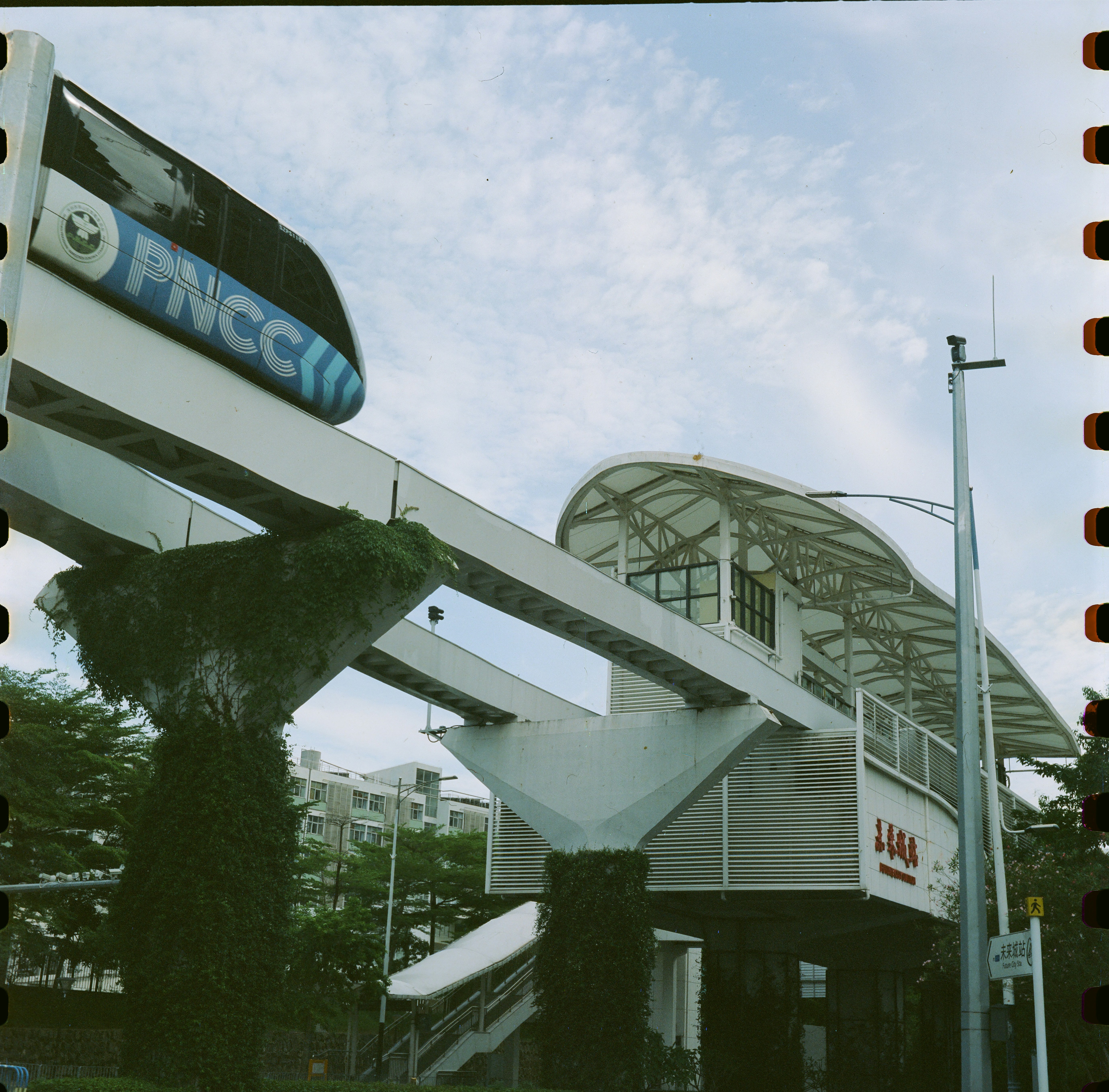 Building rail corridors on elevated bridges optimizes land use while avoiding surface traffic interference. | A monorail station is shown on a bright, cloudy day.