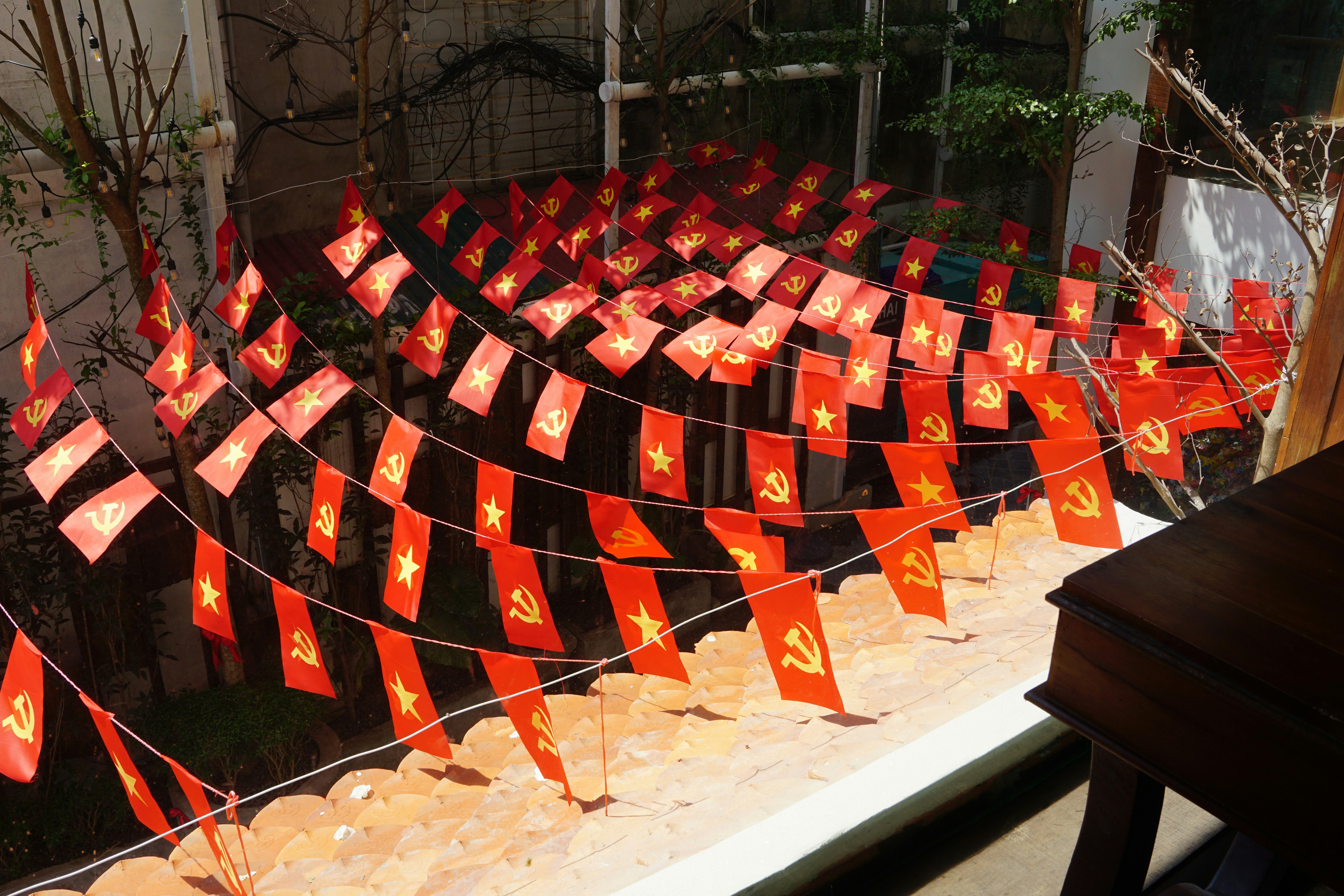 Red Flag Corridor: Sunlit Strings Across a Courtyard