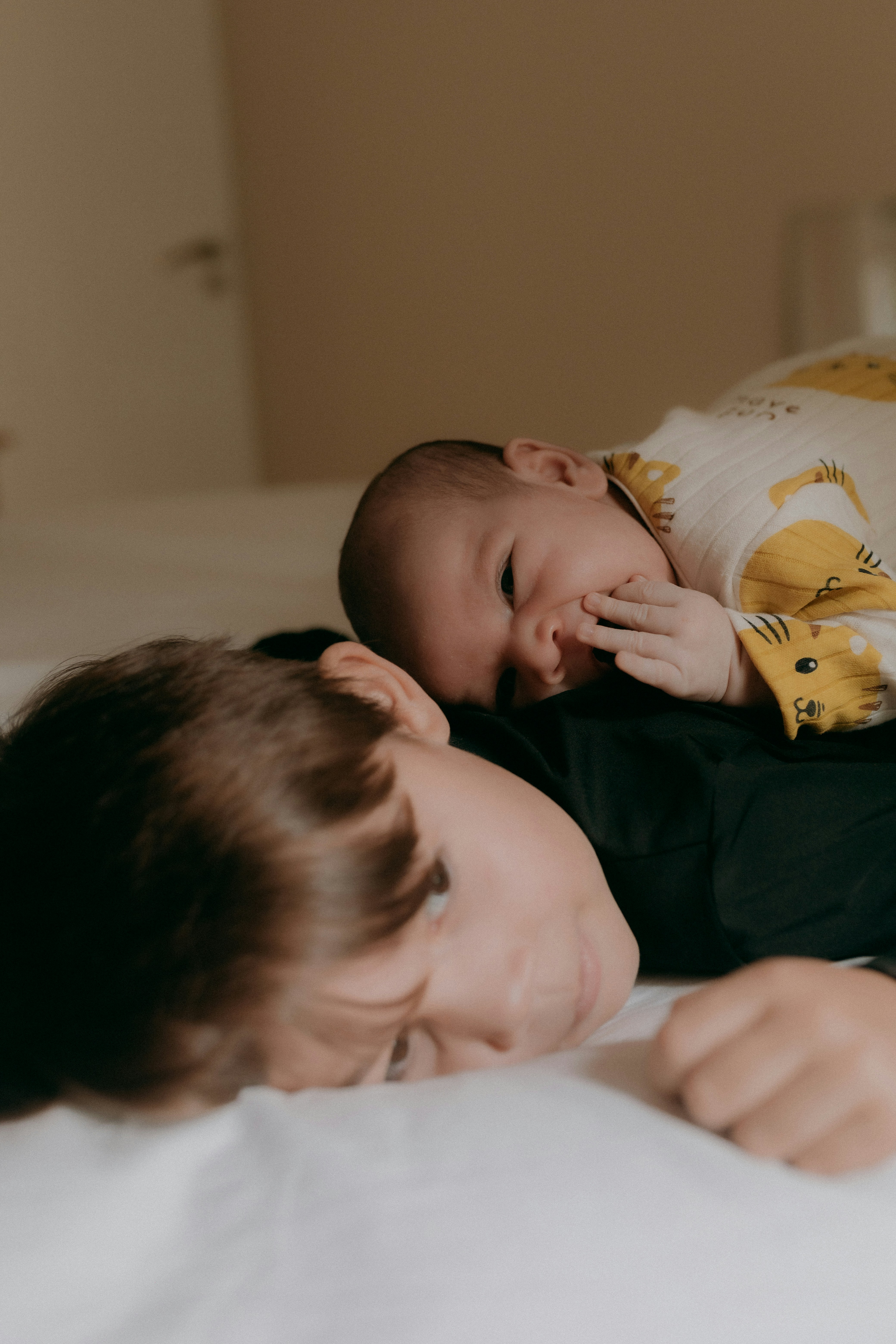 A toddler and baby cuddle on a bed. photo – Free Woman Image on Unsplash