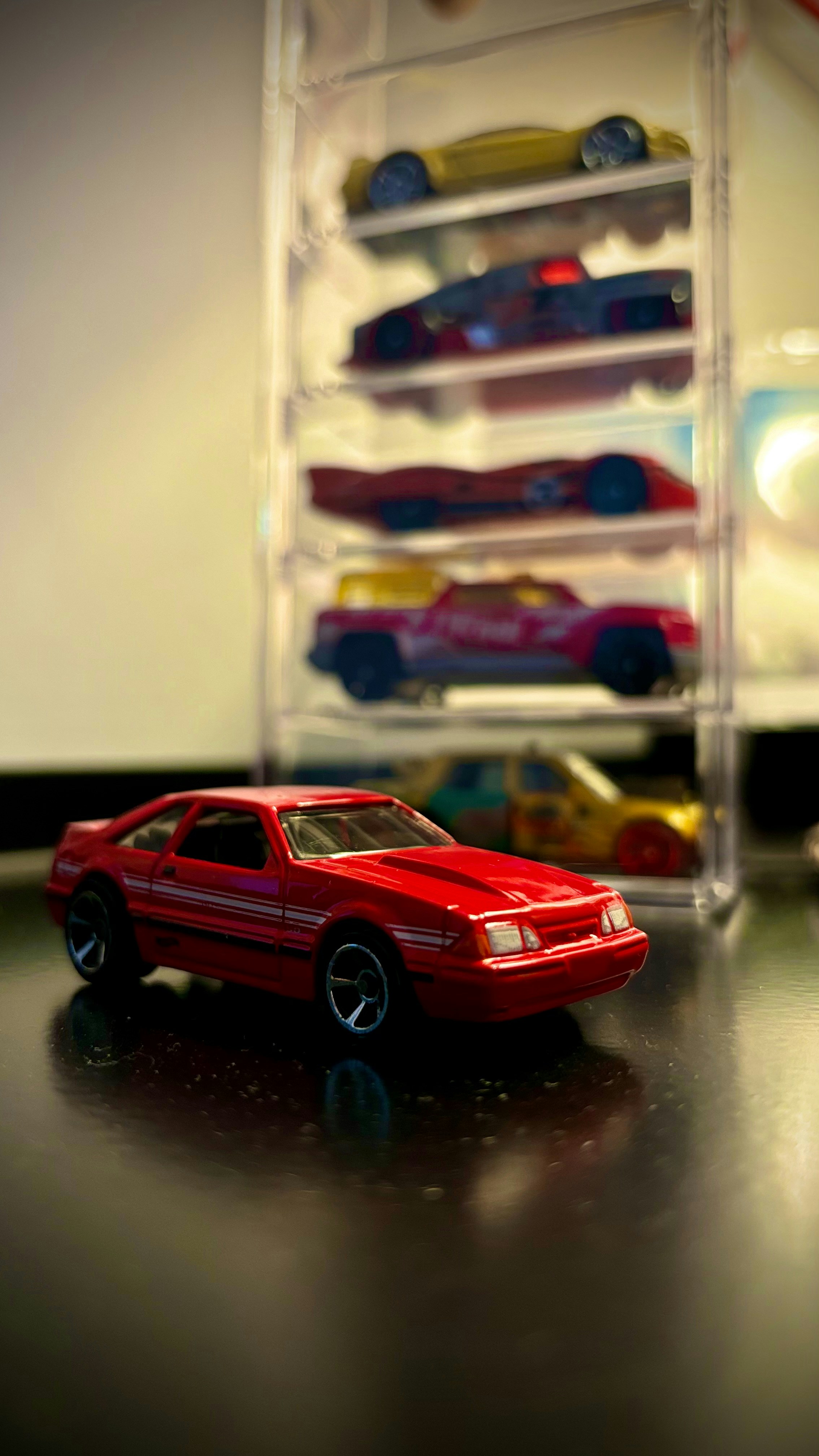 Crimson Coupe in the Spotlight: A Tiny Car on a Glossy Stage