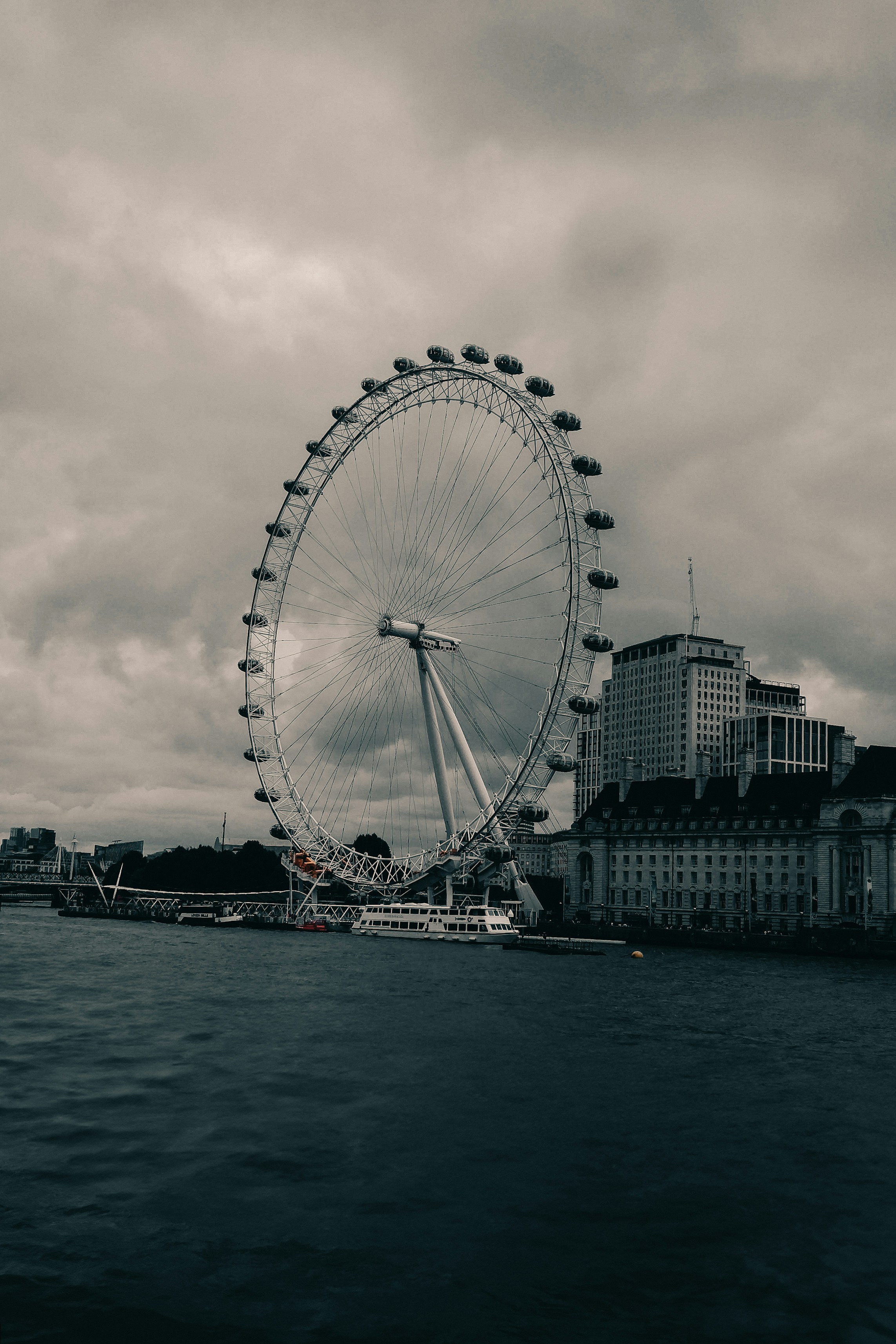 The london eye stands tall against a cloudy sky. photo – Free City ...