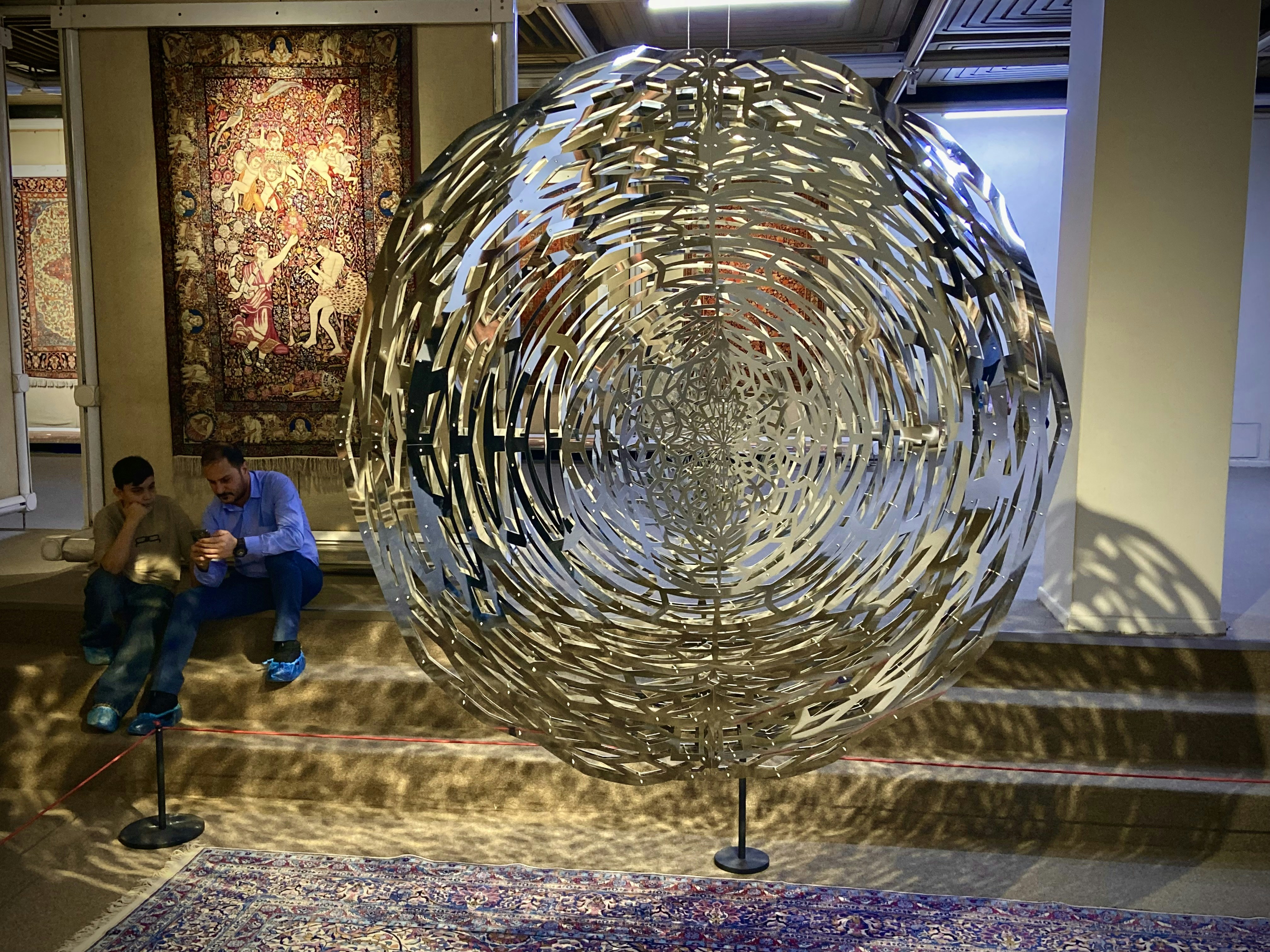 A shiny sculpture reflects a room's atmosphere.