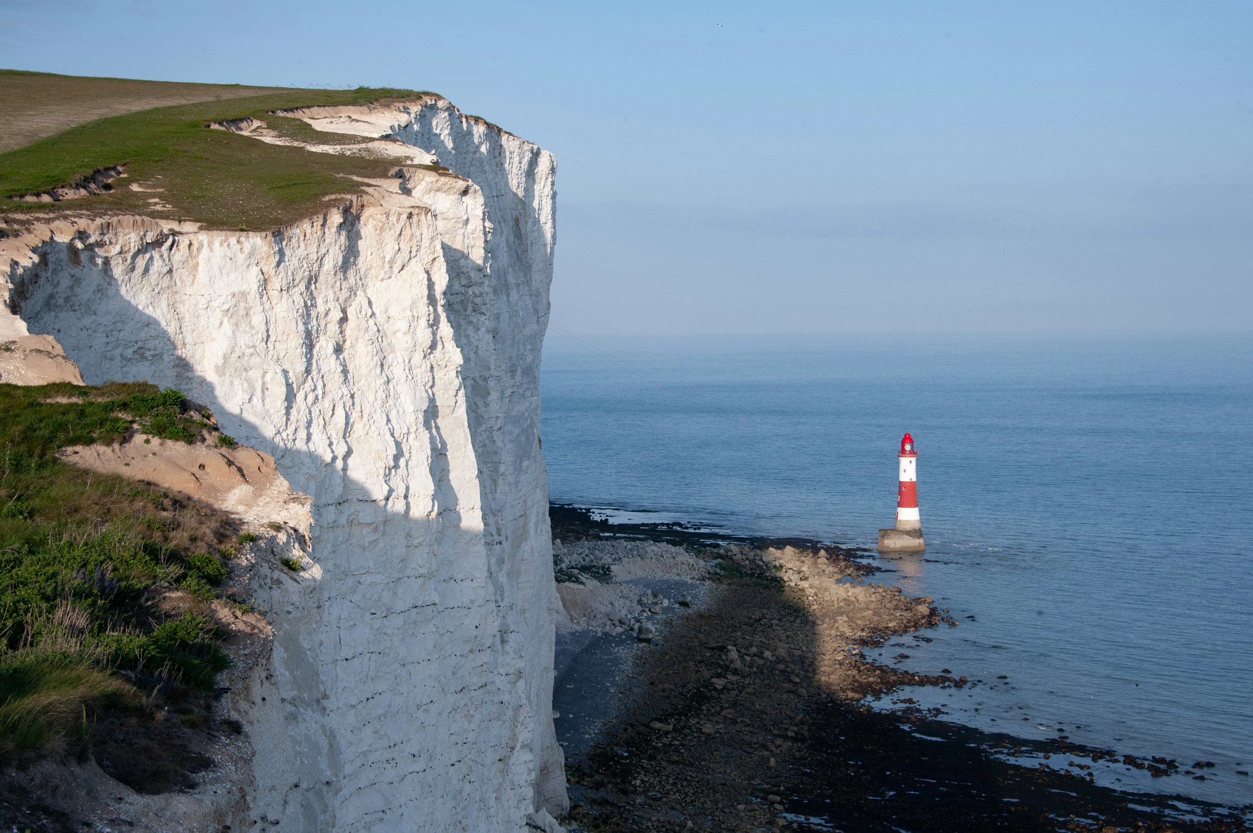 White cliffs and a lighthouse overlook the sea. photo – Free Hiking ...