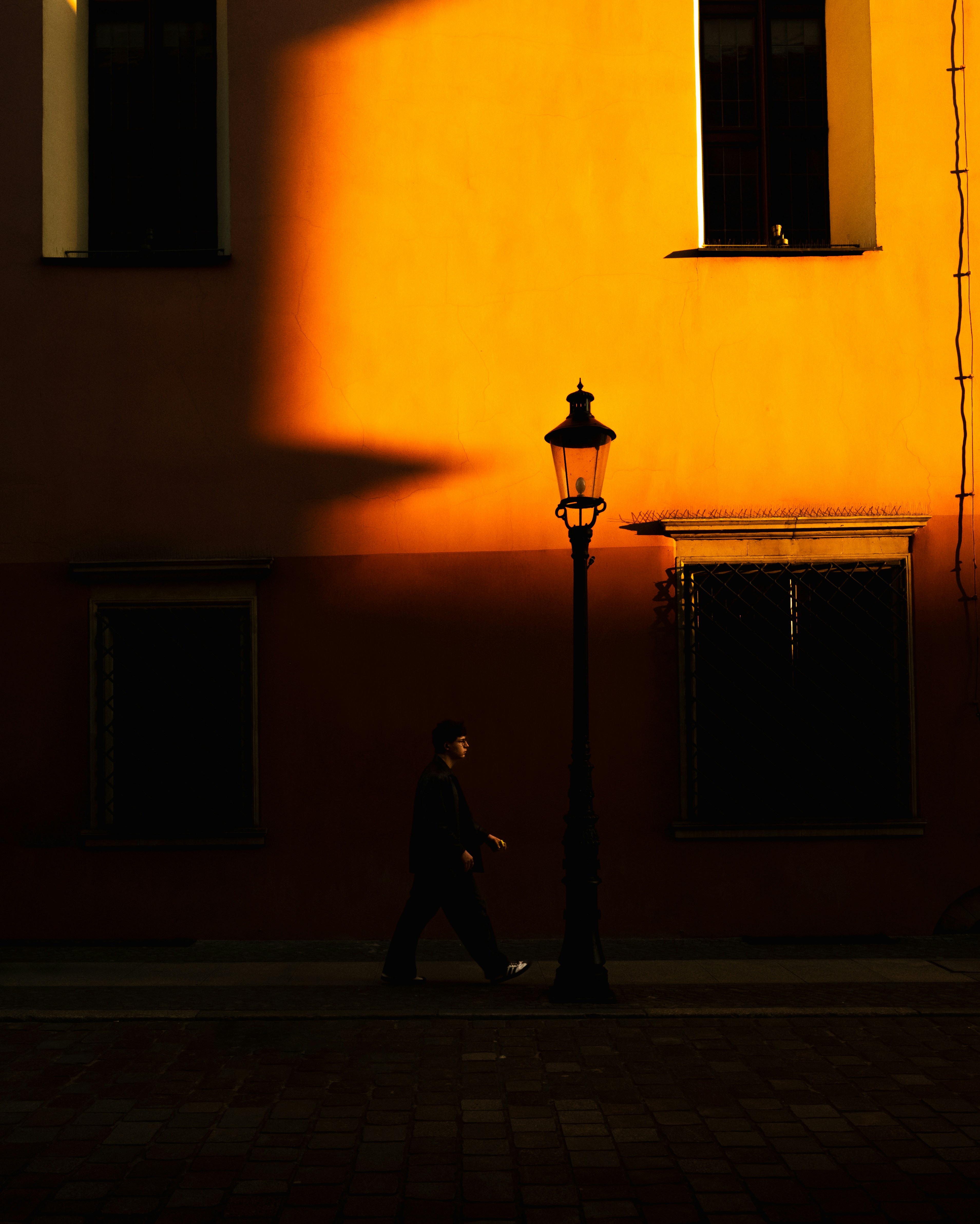 A silhouette walks past a street lamp. photo – Free Wallpaper Image on ...