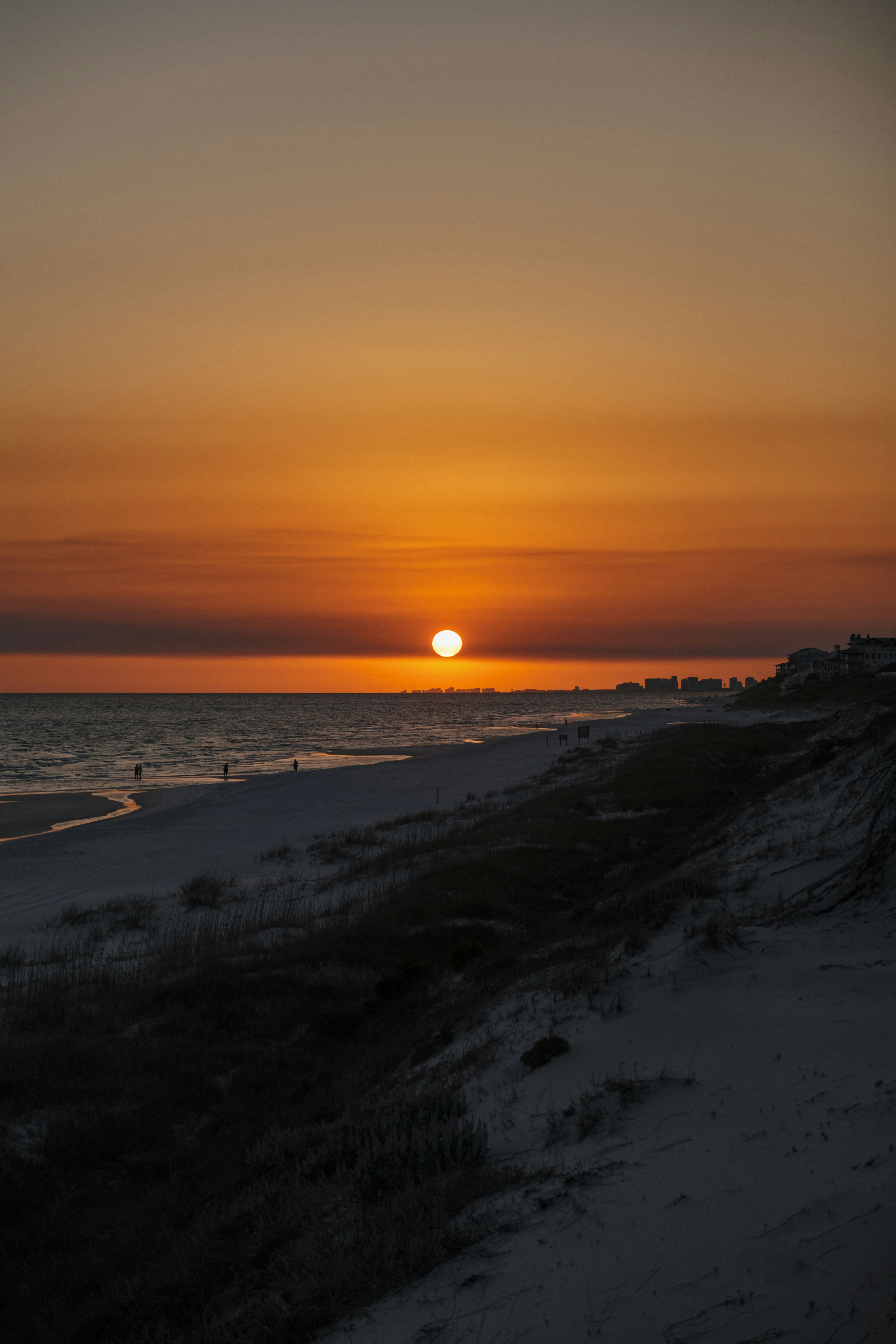 A sunset paints the sky over the beach. photo – Free Beach Image on ...