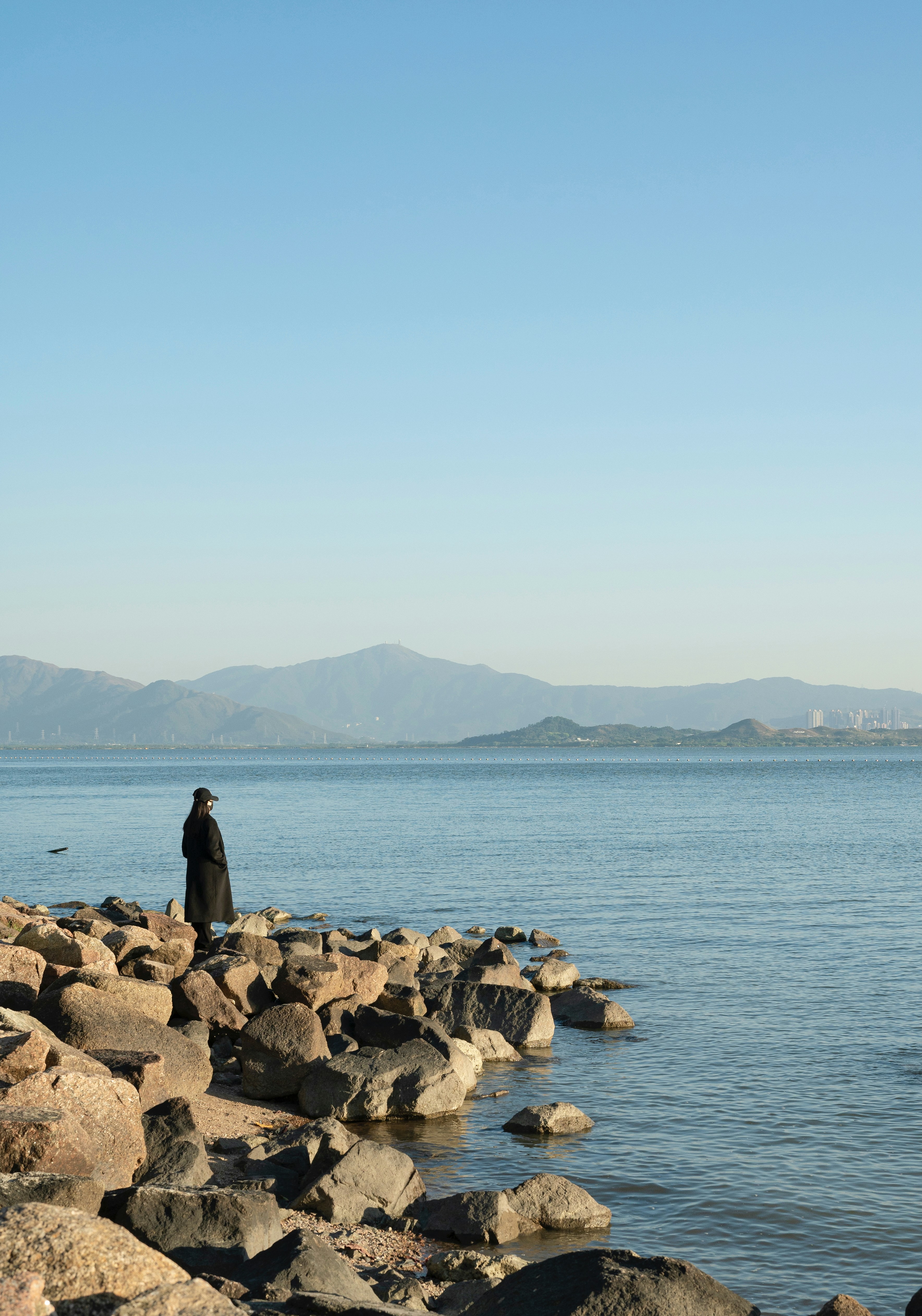 A person stands by the water, gazing. photo – Free Beach Image on Unsplash