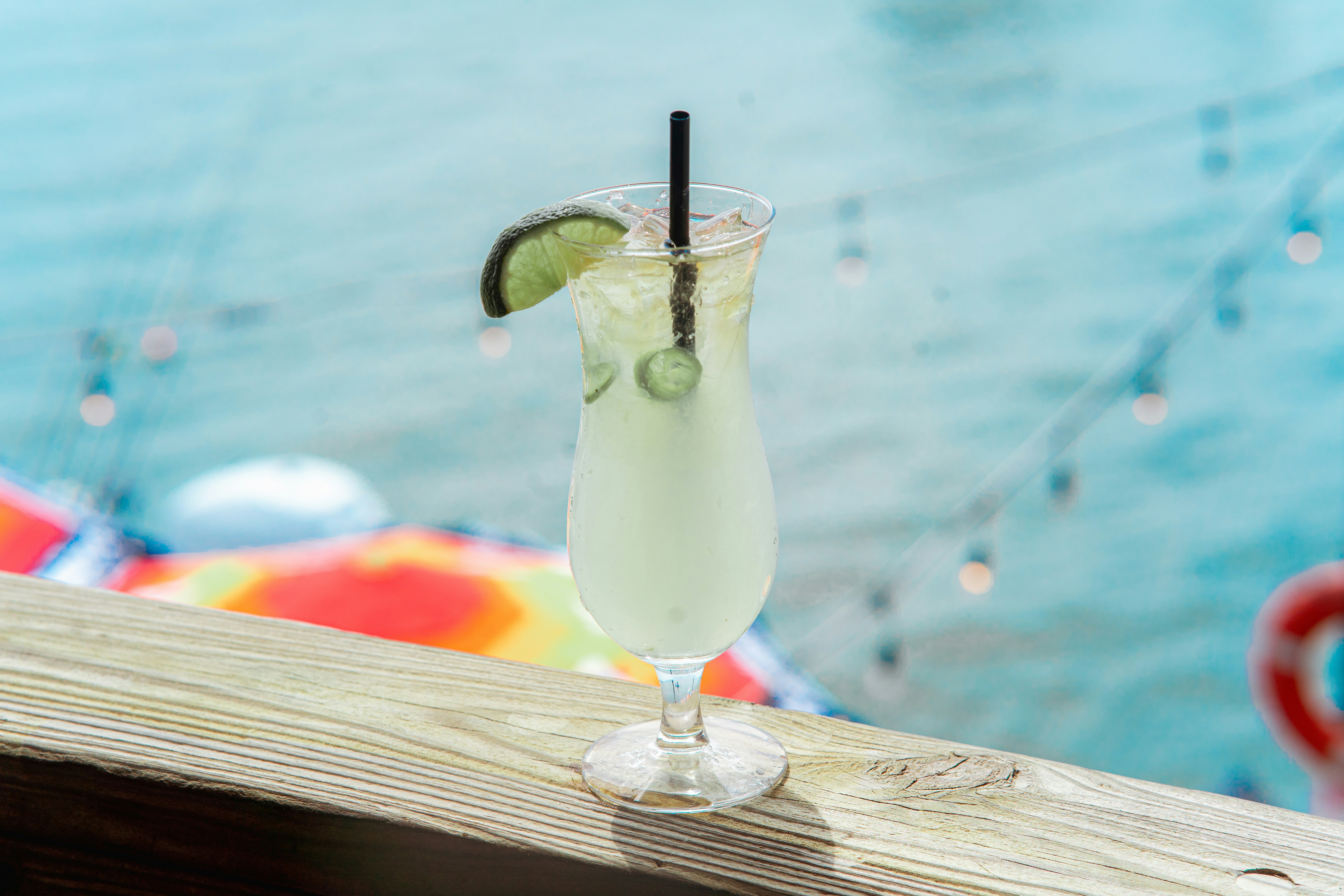 Lime-Gleam Spritz on a Weathered Rail Over Turquoise Waters