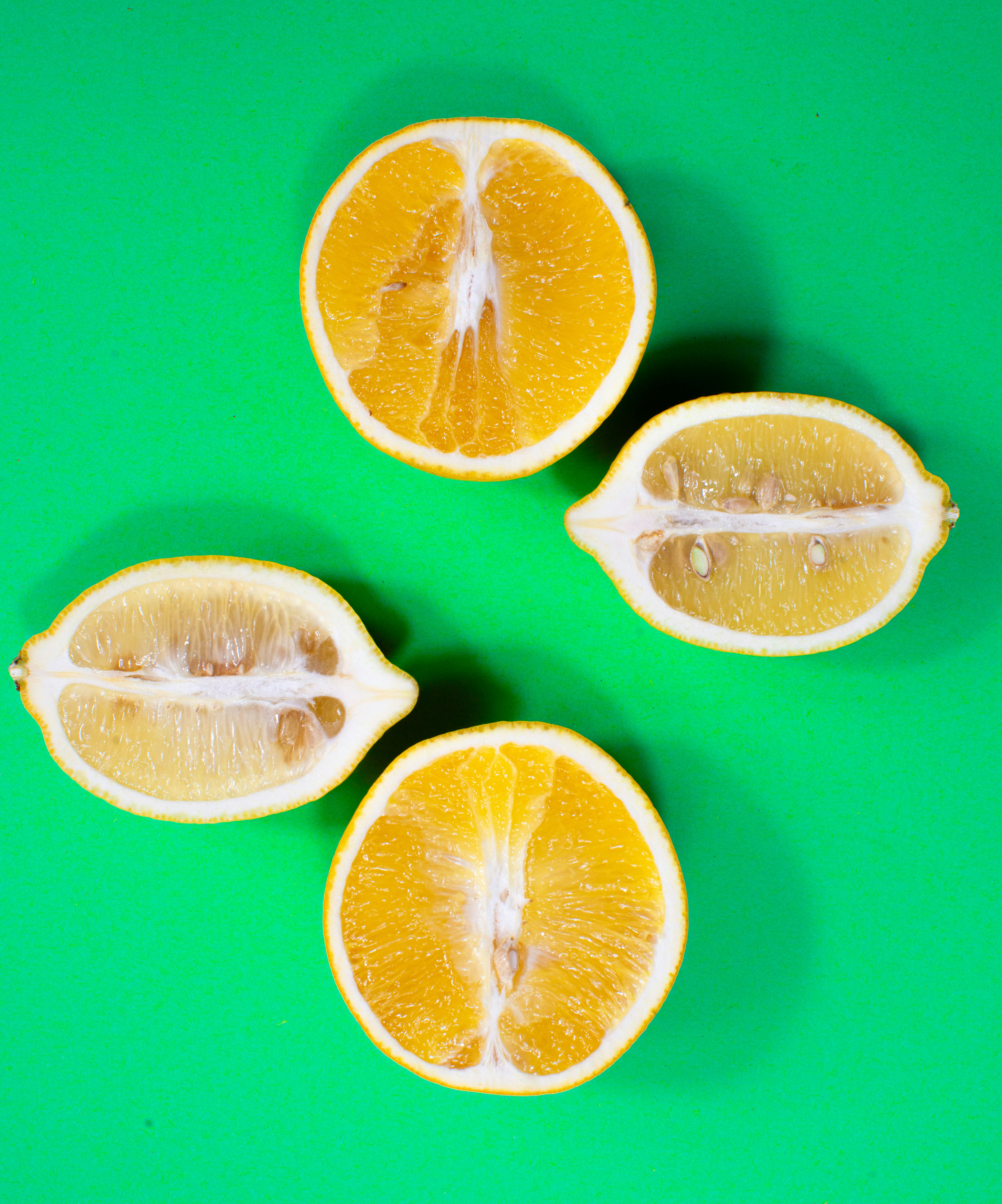 Four halves of lemons on a green surface. photo – Free Orange Image on ...