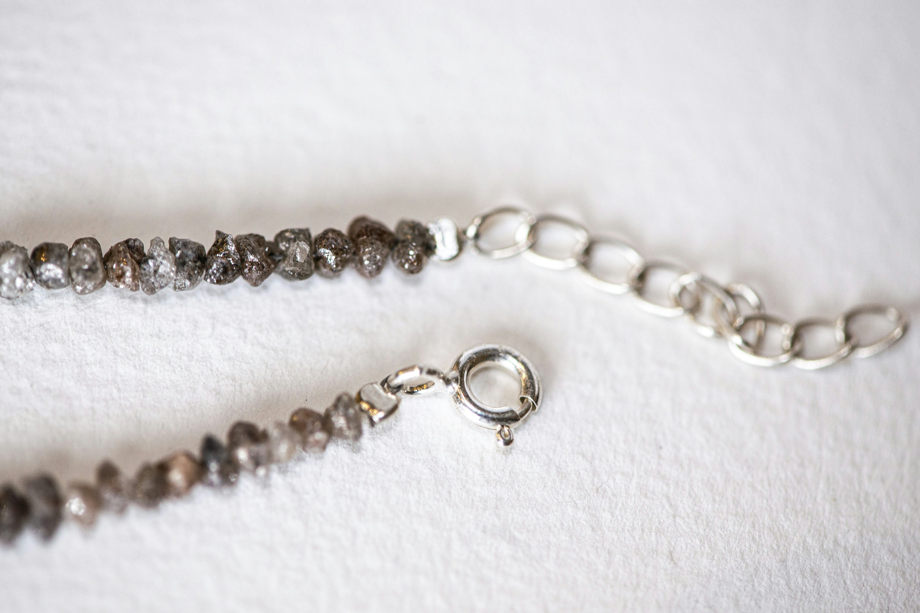 Intricate beaded bracelet featuring natural stones and a silver clasp, showcasing fine craftsmanship and design details.