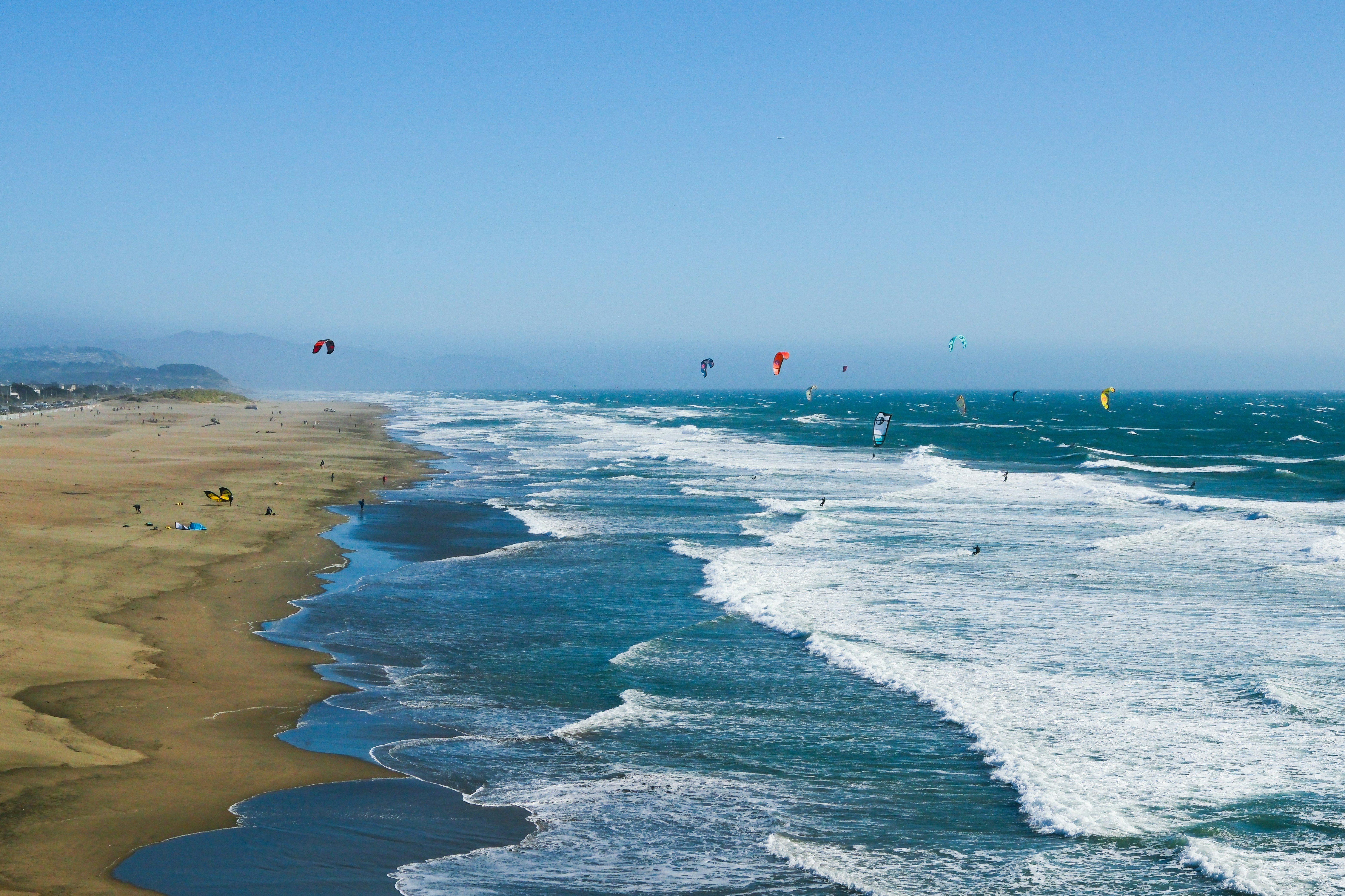 Beachgoers enjoy kitesurfing on a bright, sunny day. photo – Free Beach ...