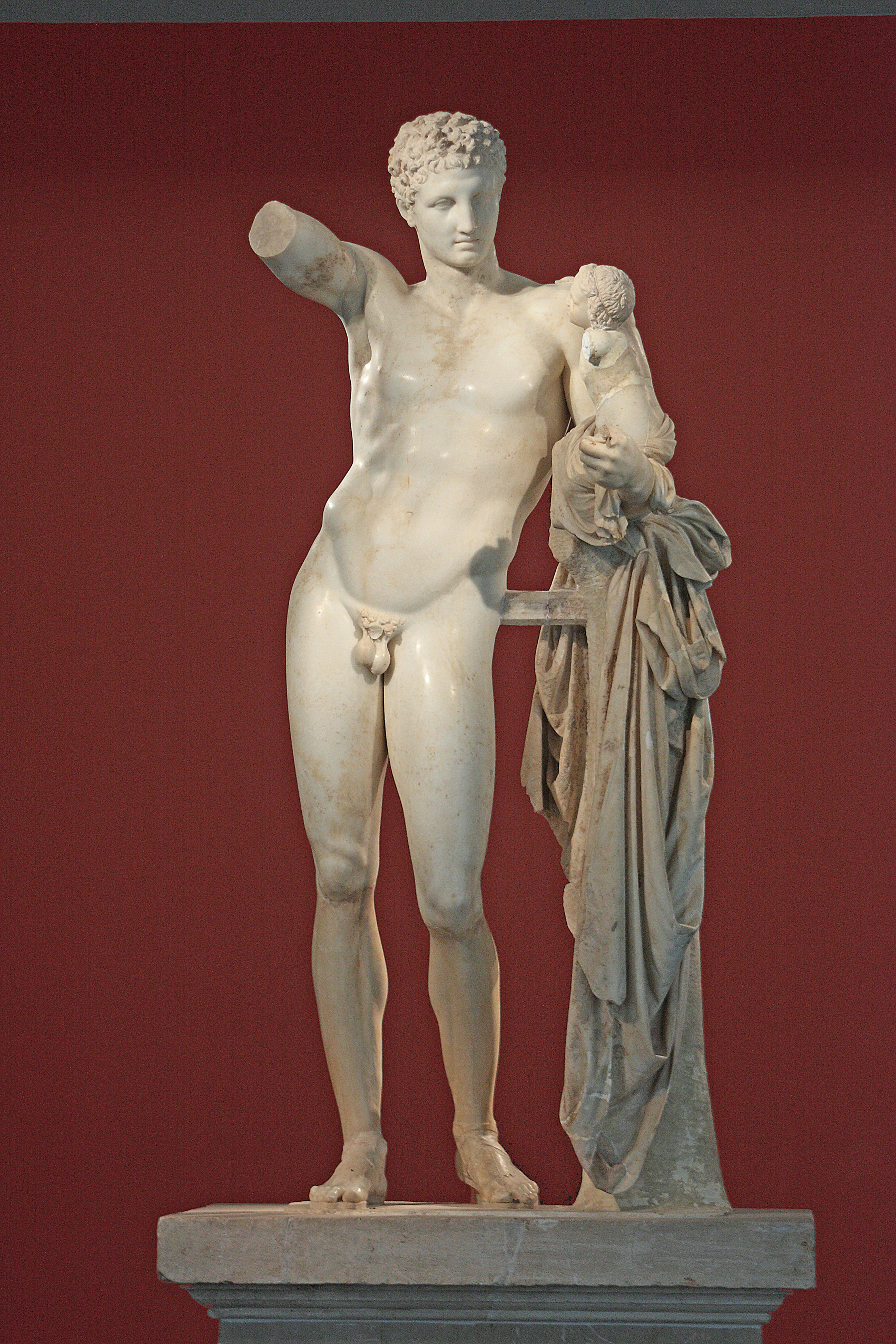 The ancient god Hermes (Ermis) holding his infant brother god Donysus. Famous work of the sculptor Praxiteles. | A marble sculpture of a greek god.