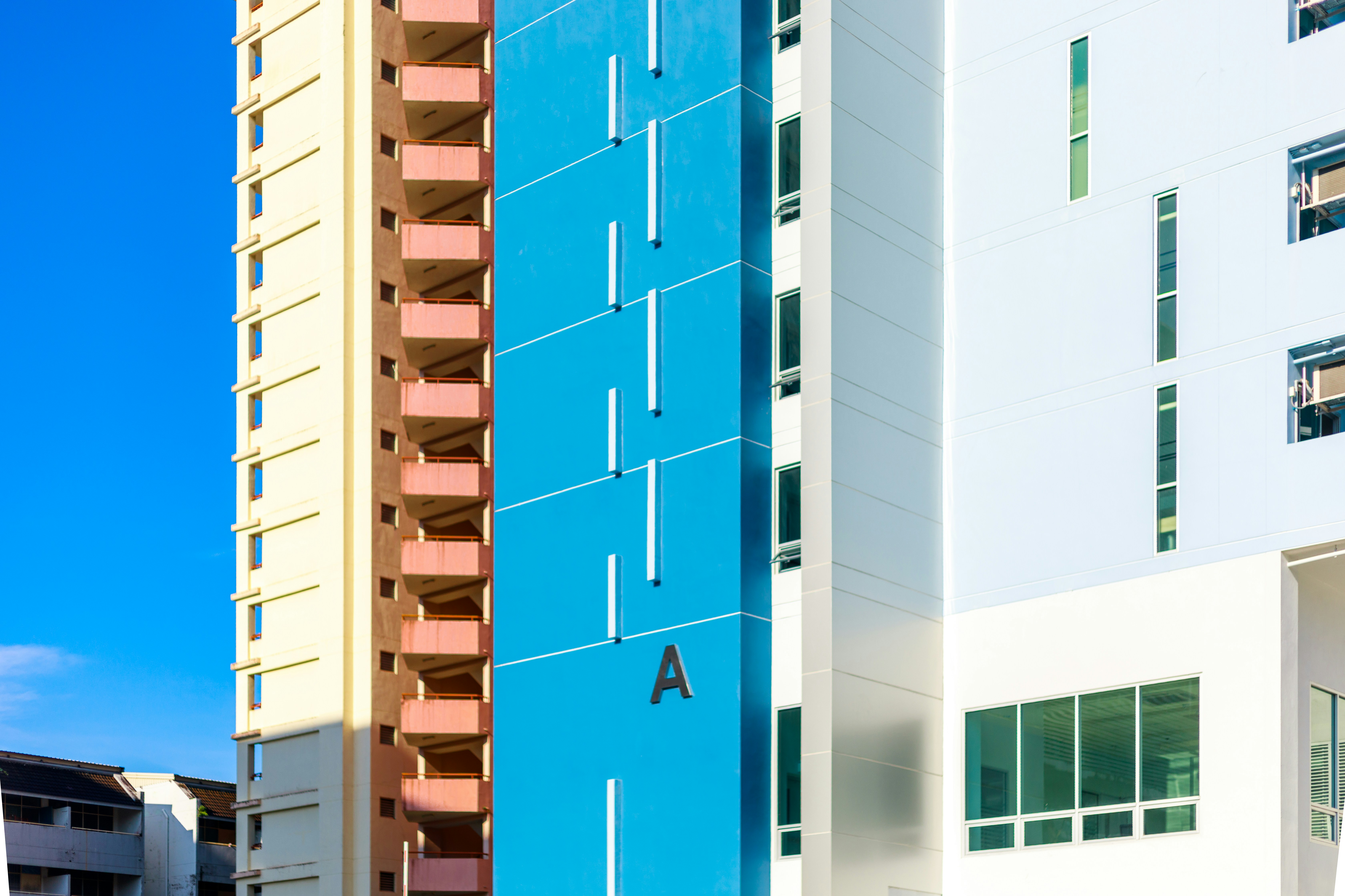 A colorful high-rise building stands brightly under sunlight. photo ...