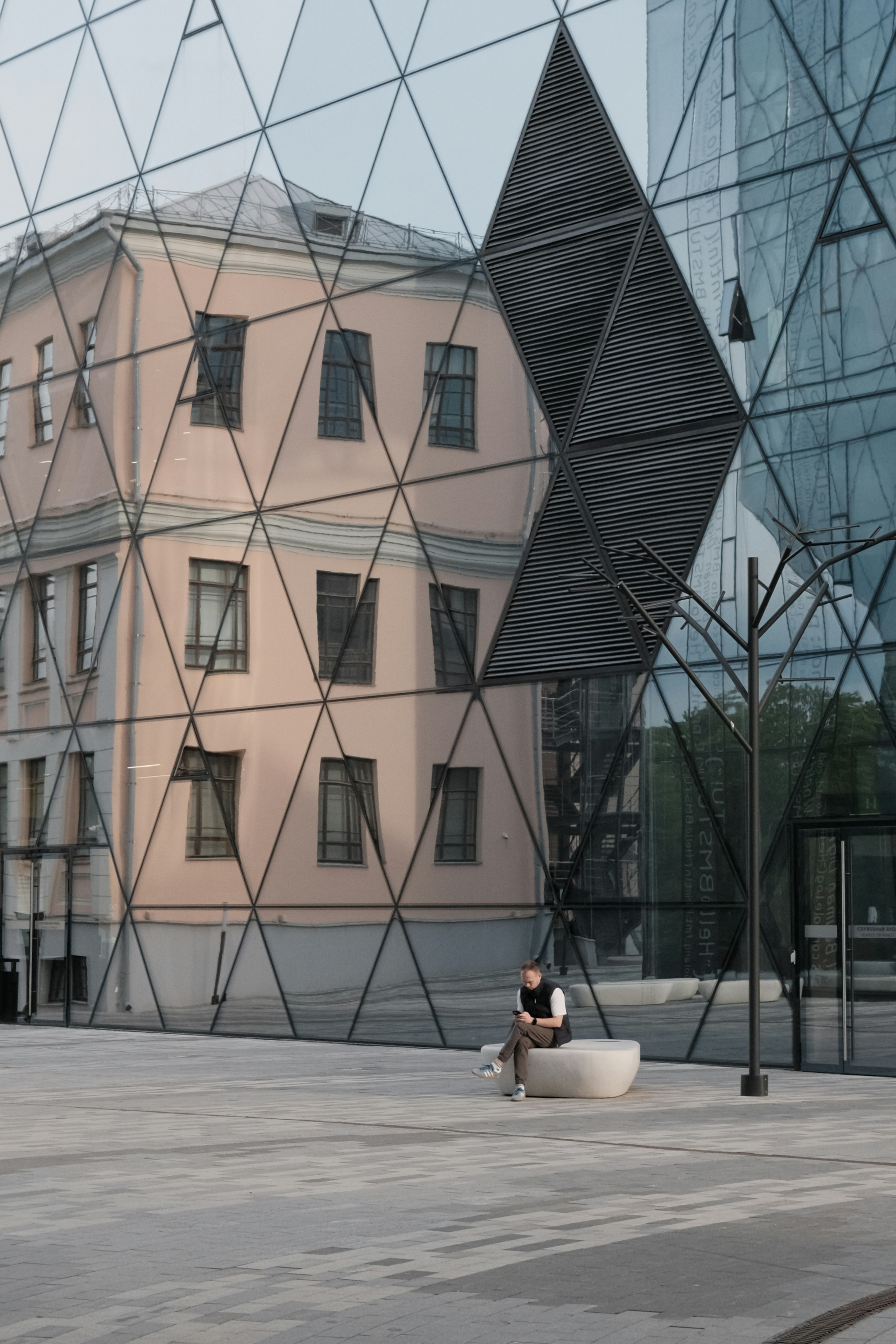 Quiet Moment on a Bench Before the Diamond Glass Facade