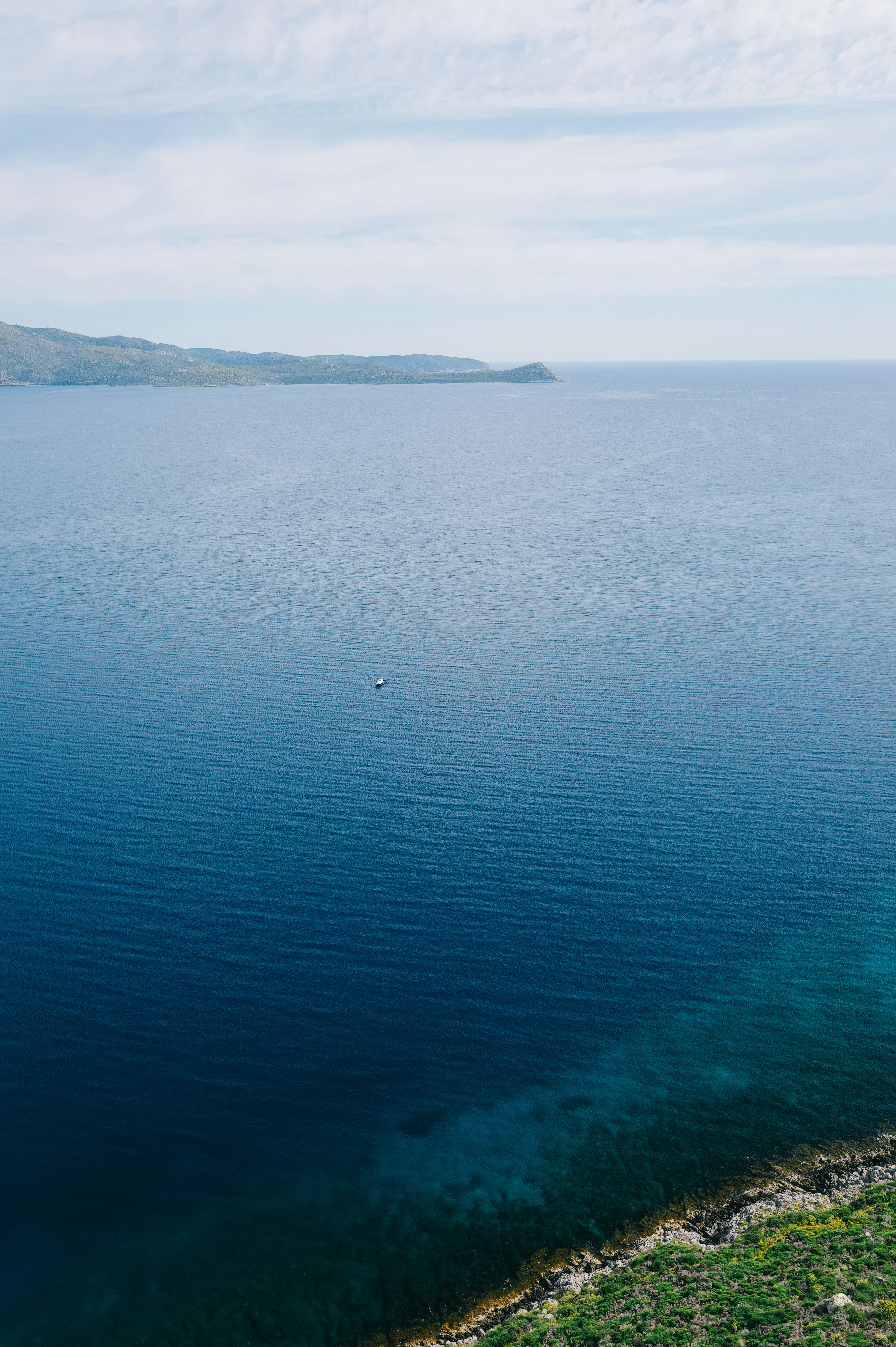 A wide blue ocean meets a distant shoreline. photo – Free Land Image on ...