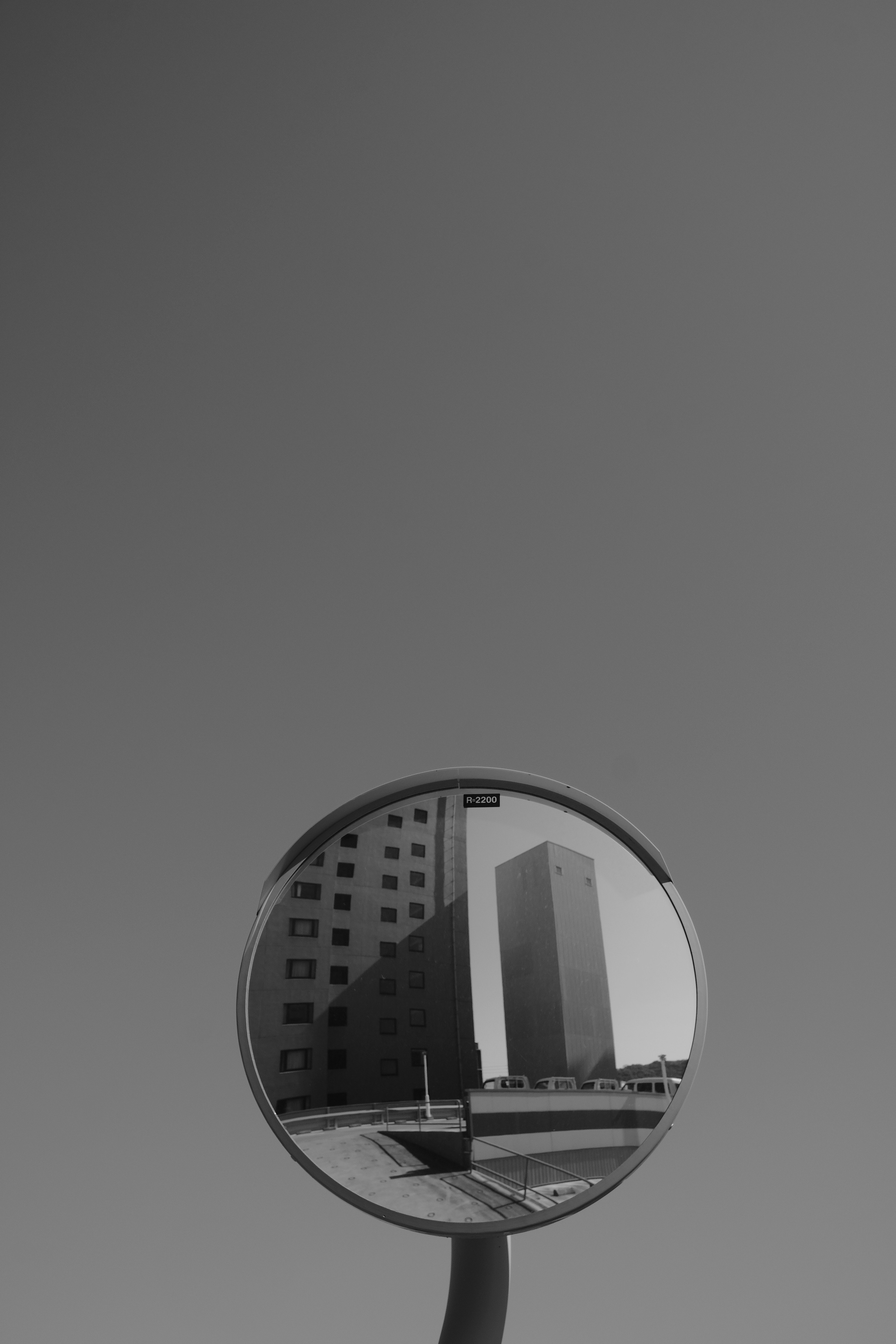 Buildings reflected in a circular mirror.
