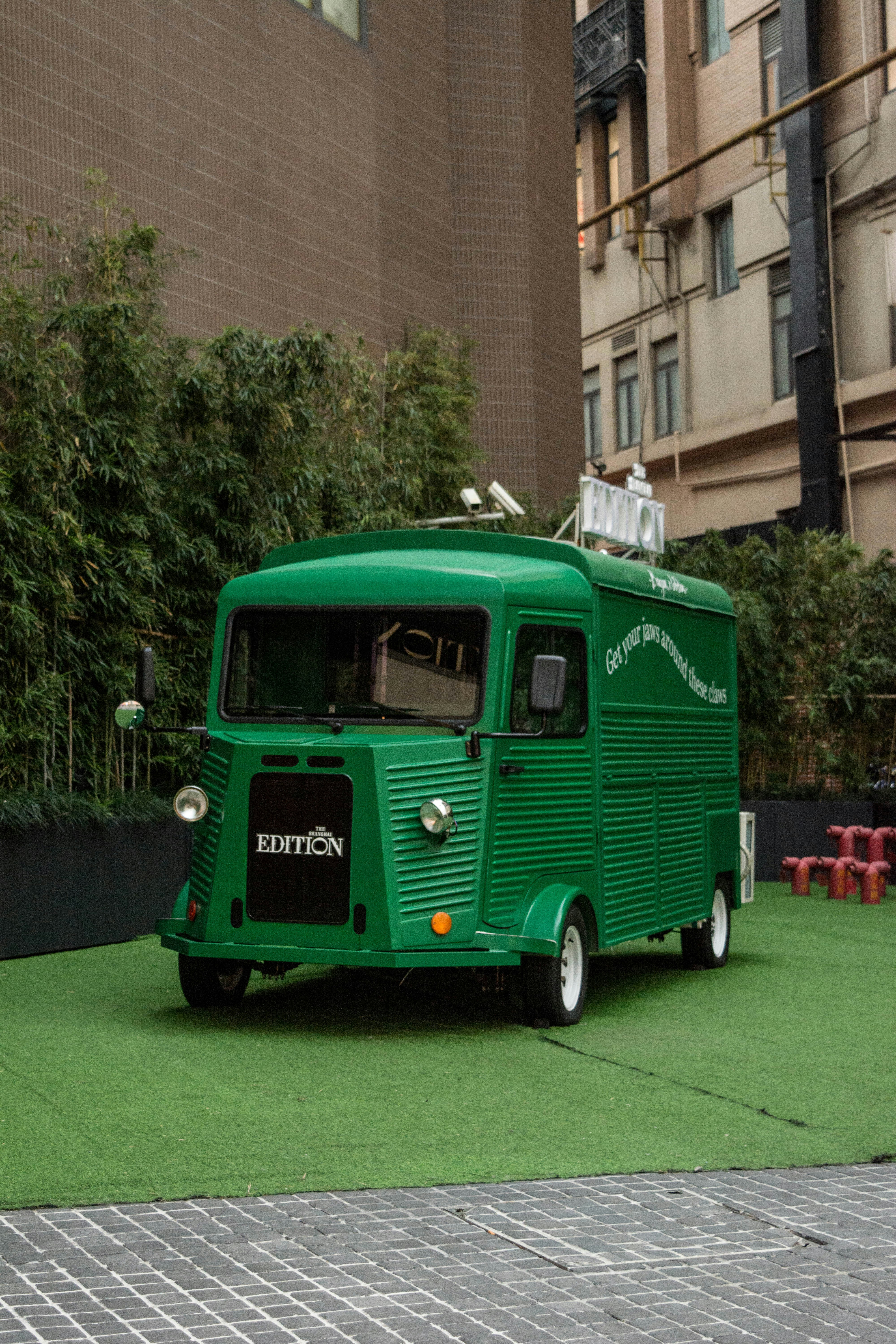 Nanjing Pedestrian Street, a tremendous shopping street in Shanghai, with multiple outlets and boutique hotels. | A green food truck is parked outdoors.