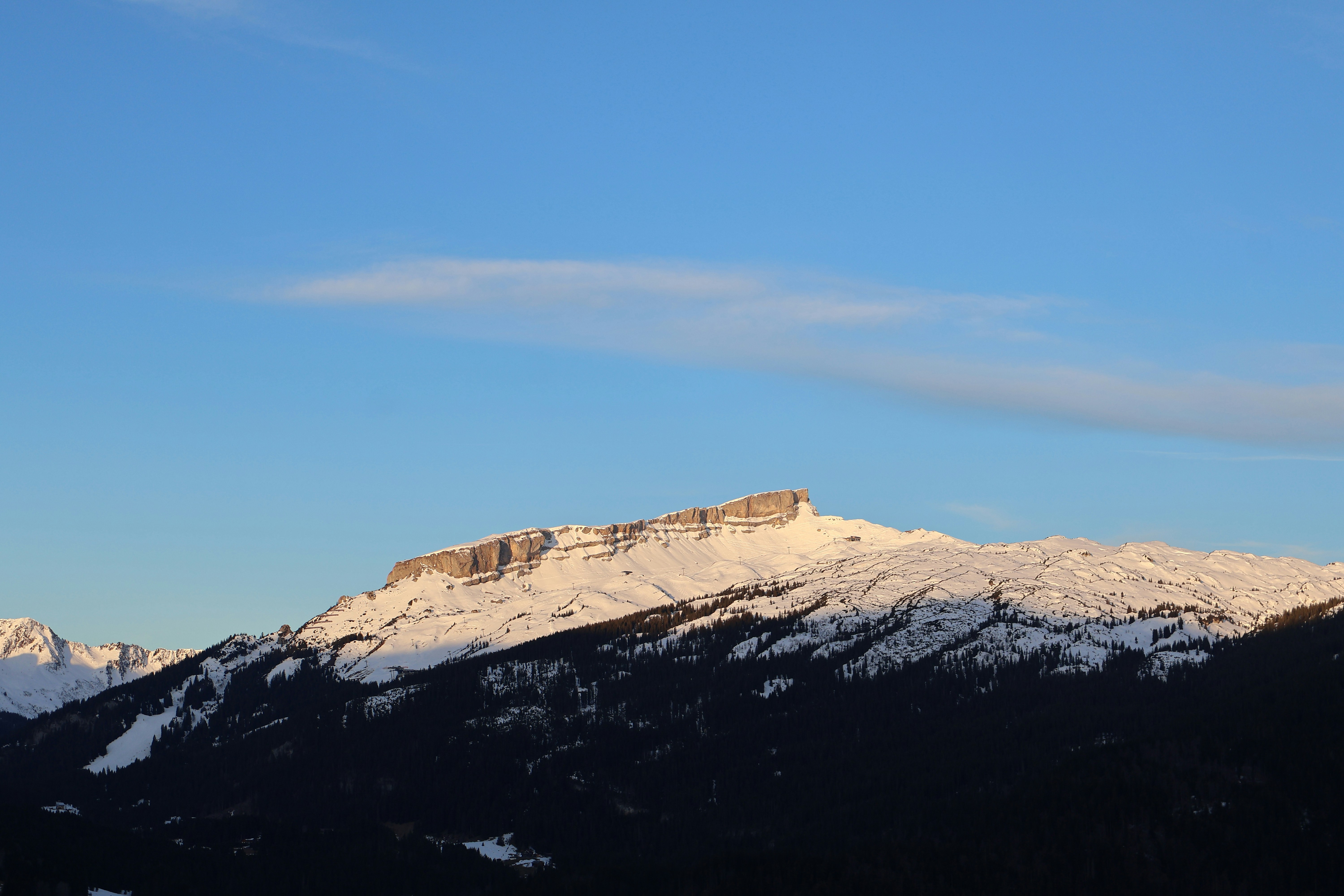 Majestic snow-covered mountain peak under a clear blue sky, showcasing the natural beauty of alpine landscapes.
