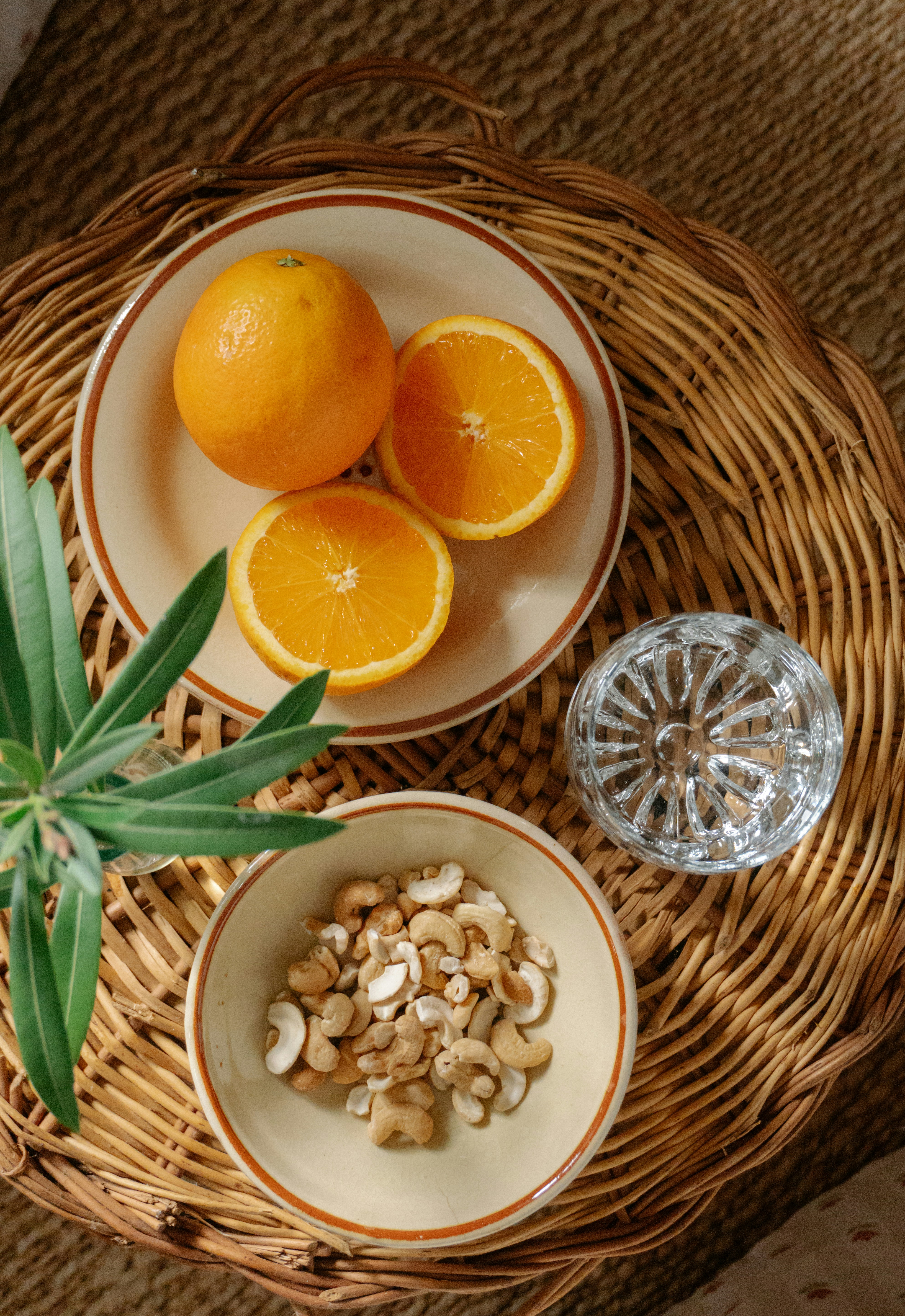 Oranges and nuts sit on a wicker tray.