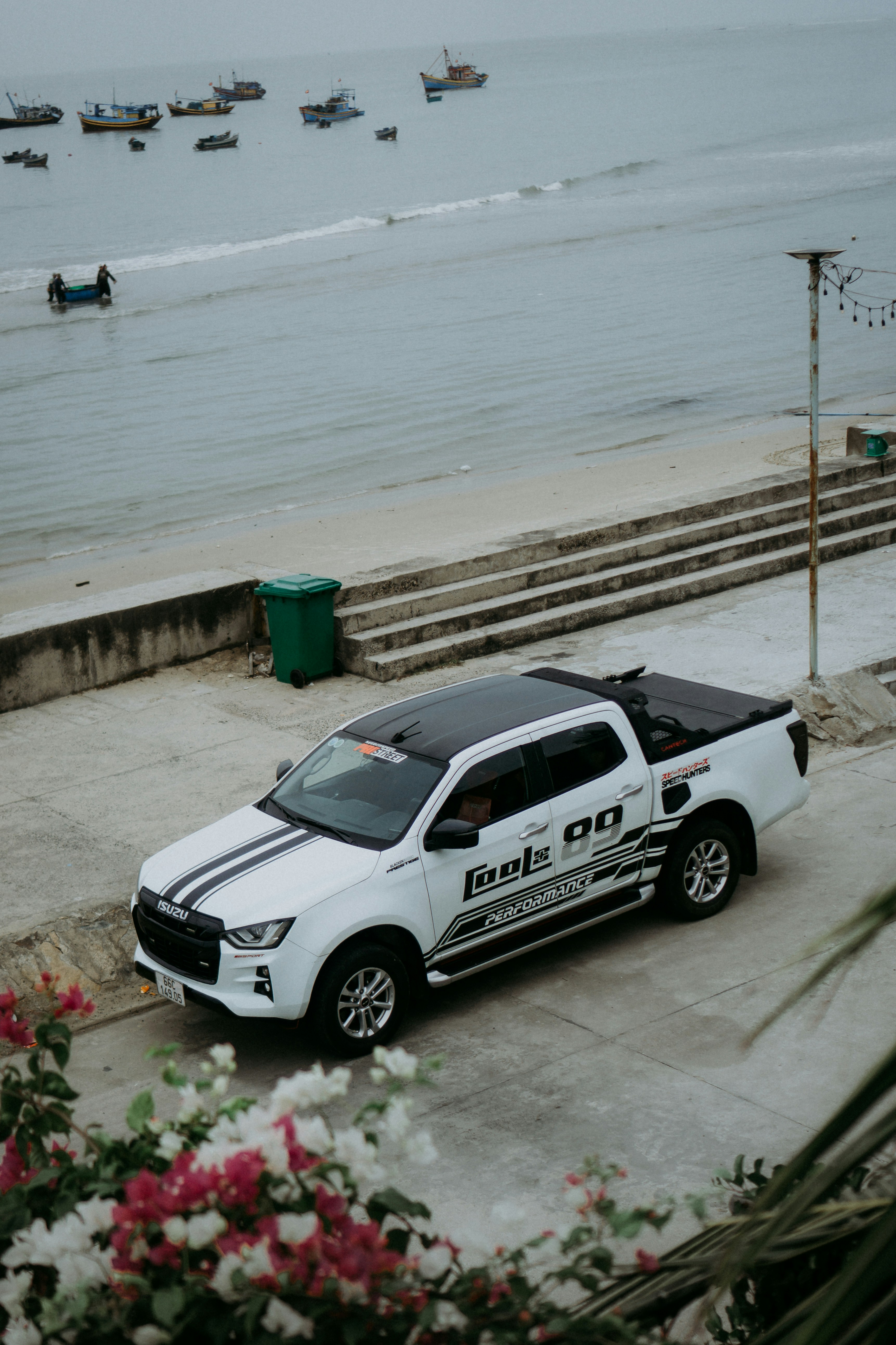 White pickup at the seaside: lines, logos, and distant boats