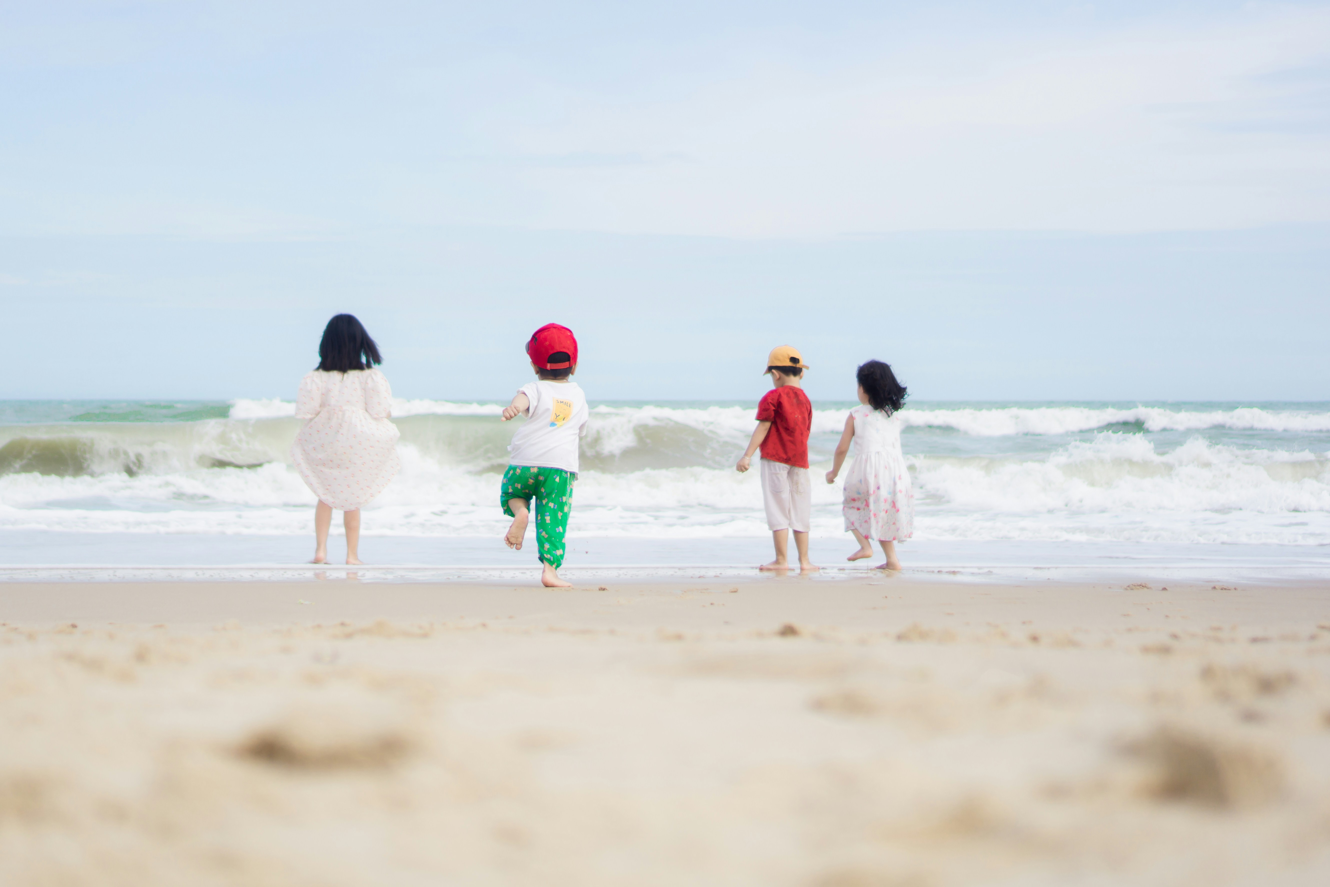 Children run towards the ocean at the beach. photo – Free Portrait Image on Unsplash