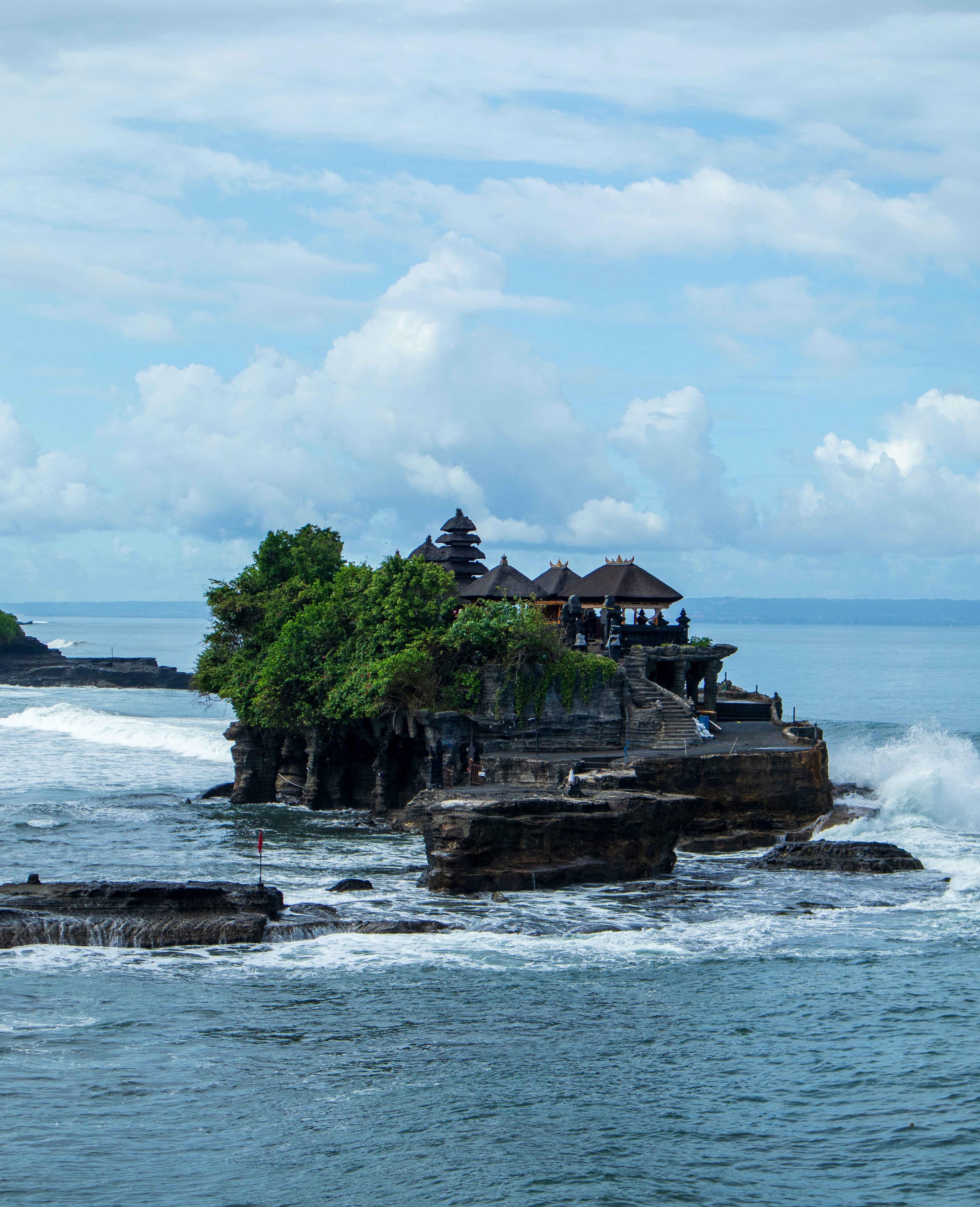 A temple stands atop a rocky island in the ocean. photo – Free Building ...