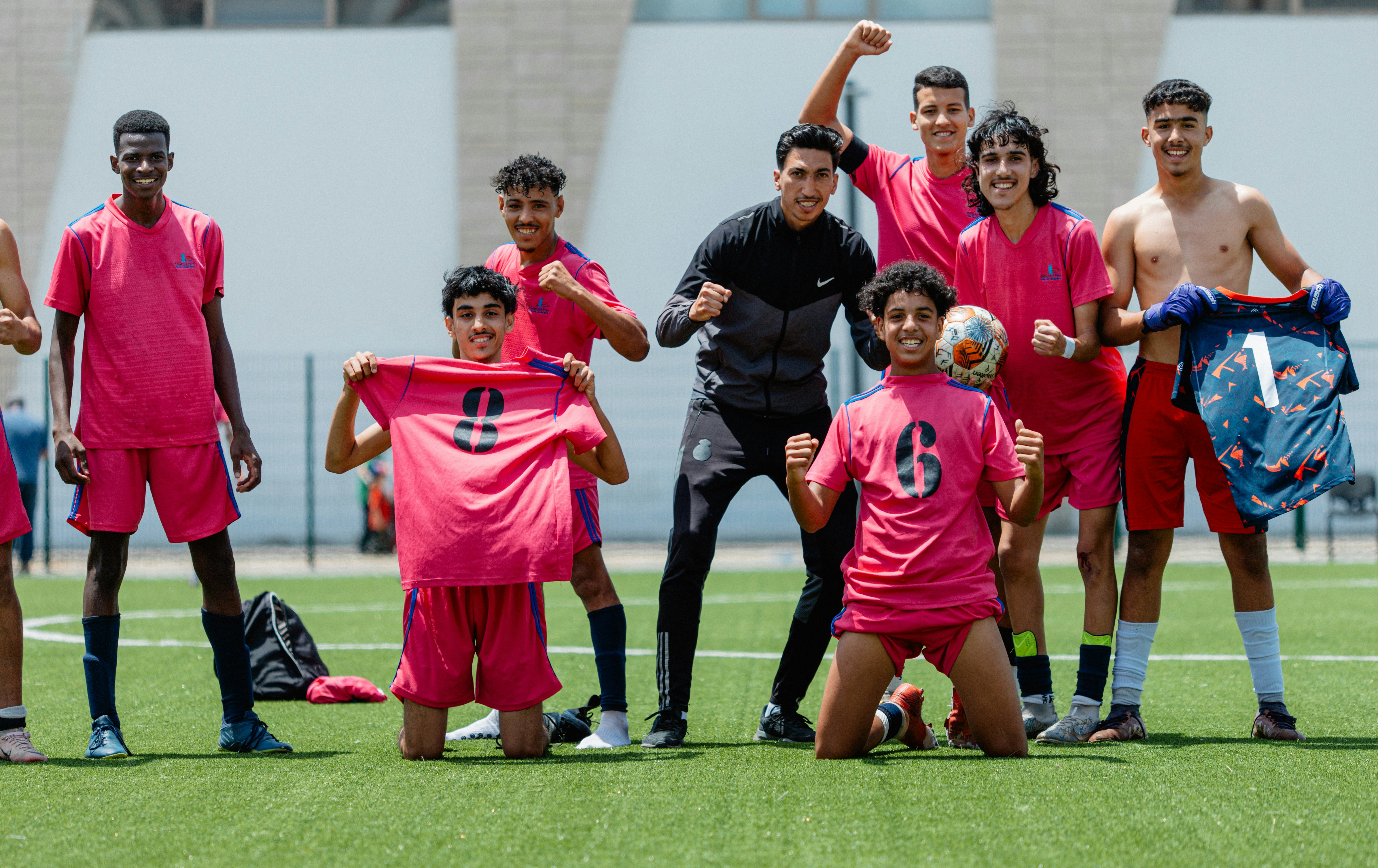Soccer players in pink uniforms celebrate on the field. photo – Free ...