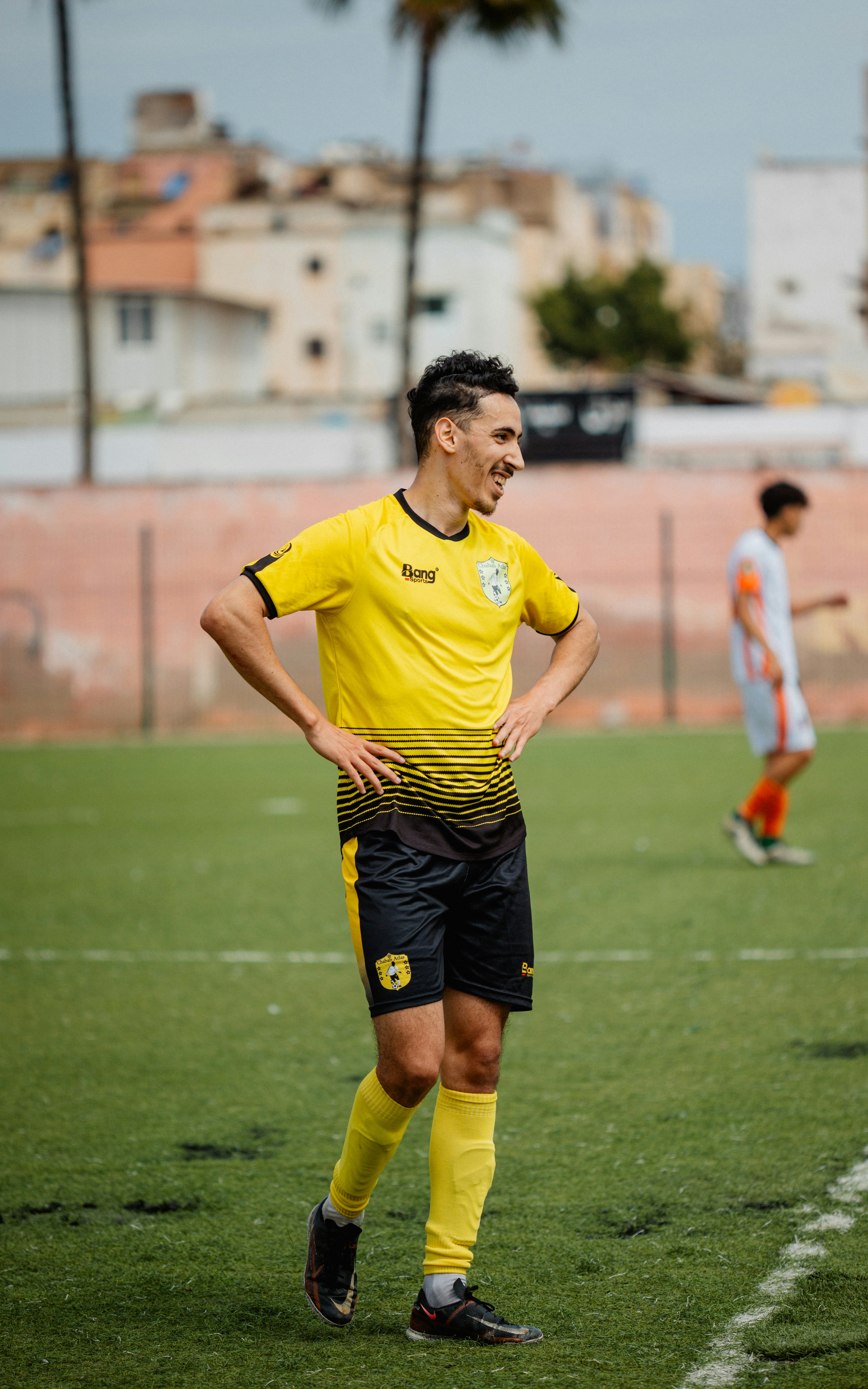 A soccer player stands smiling on the field. photo – Free Human Image ...