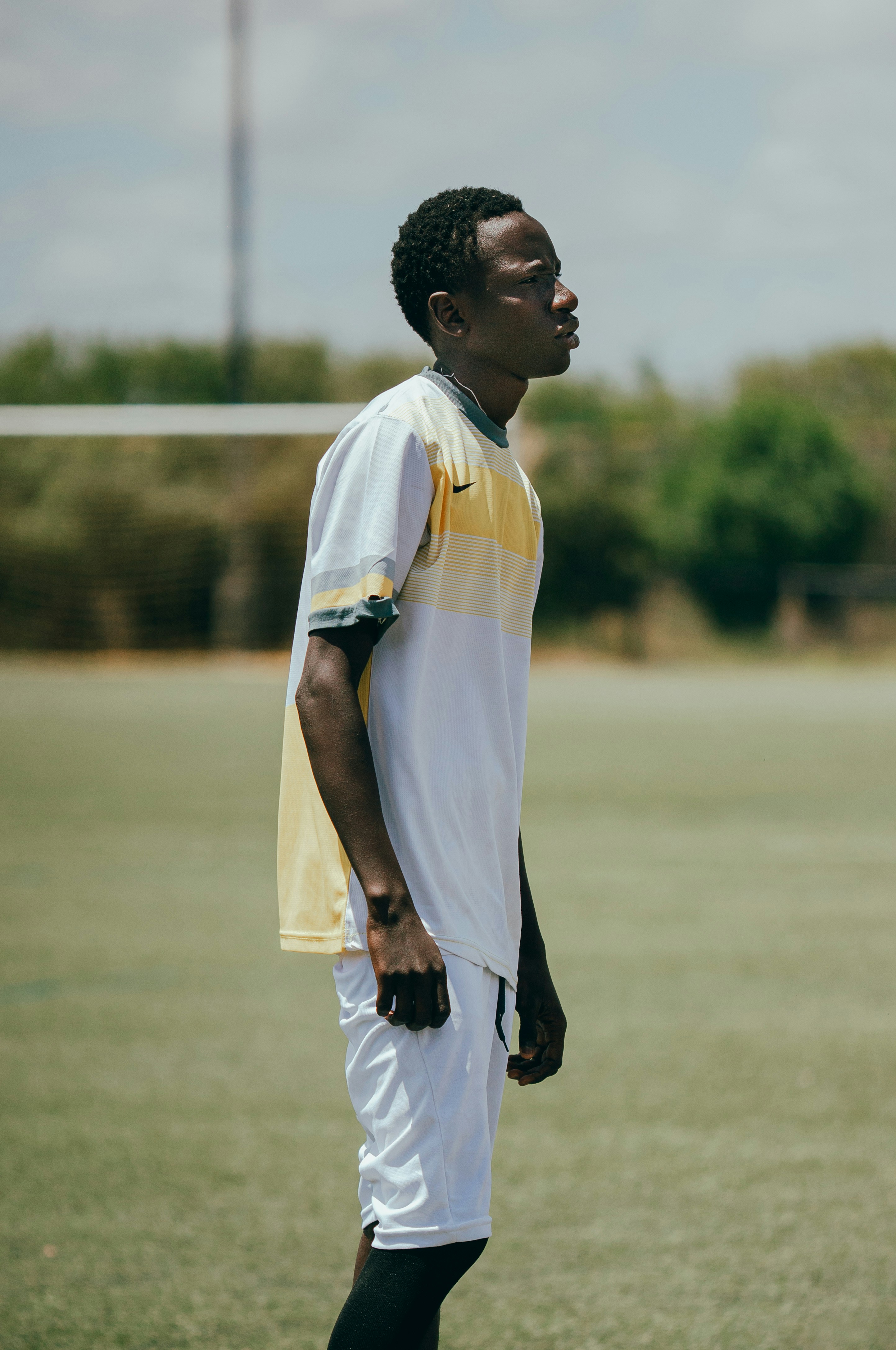 Side-profile Soccer Player in Sunlit Field