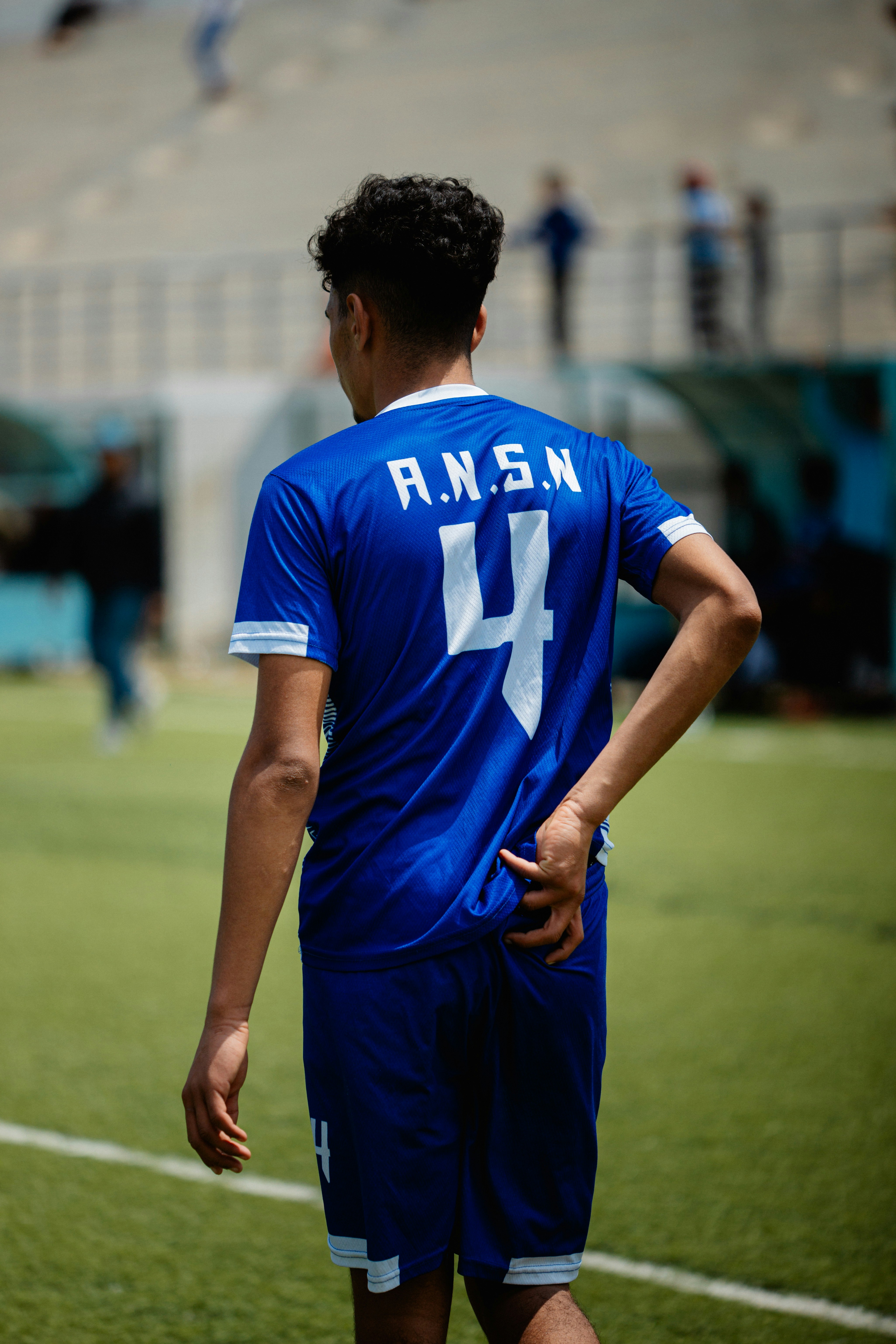 A soccer player stands on the field. photo – Free Human Image on Unsplash