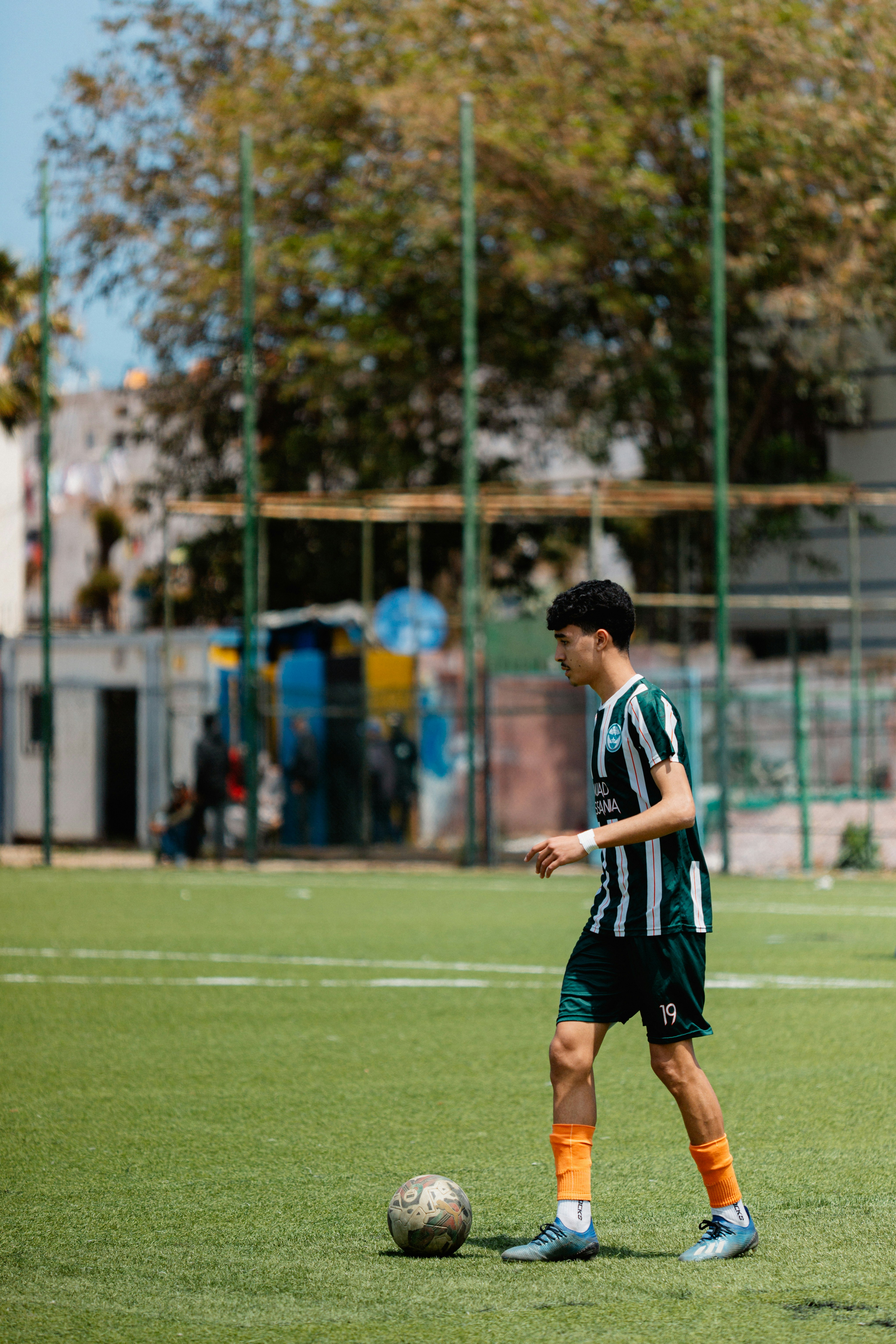 A soccer player kicks the ball on the field. photo – Free Human Image ...