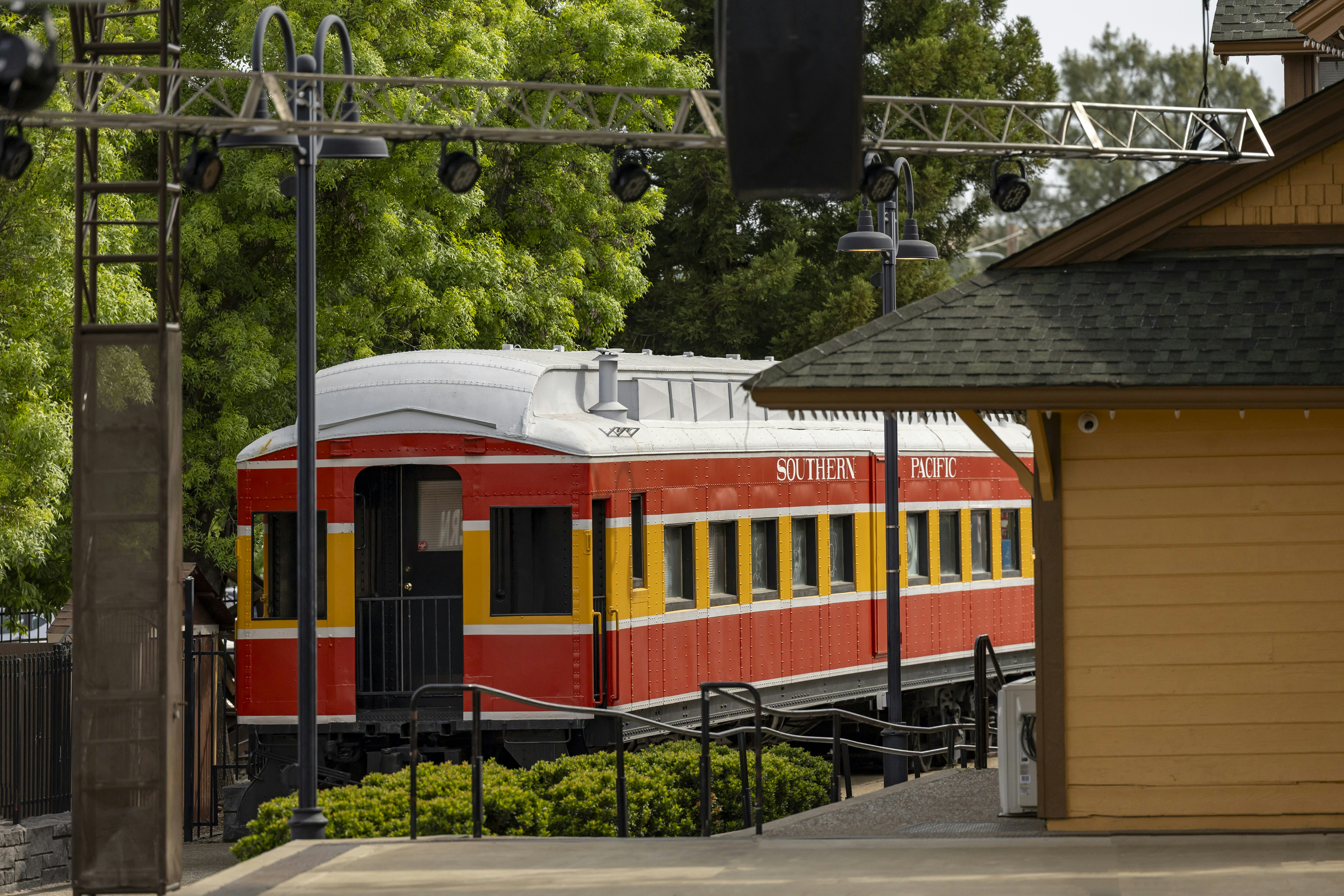 Here is a short caption for the image: a red train car is parked next ...