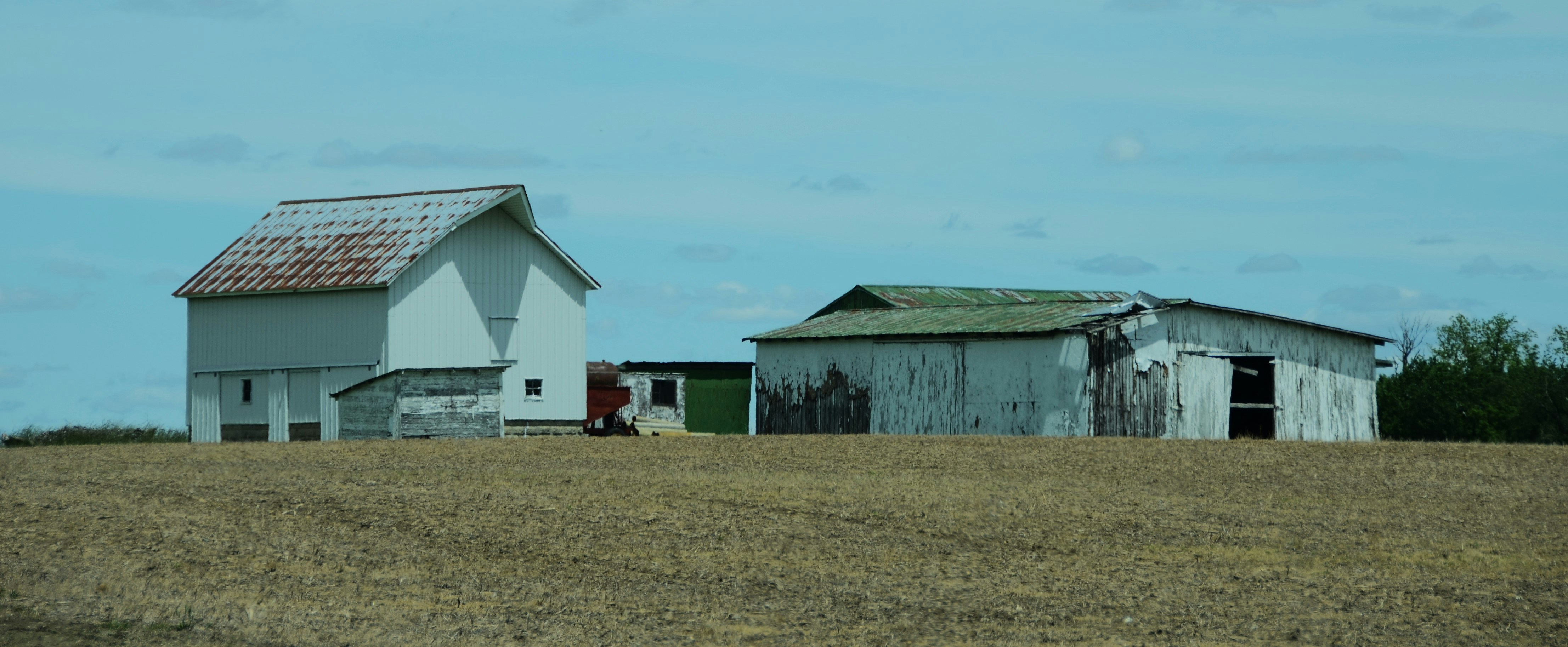 Farm buildings stand against a bright blue sky. photo – Free Building ...