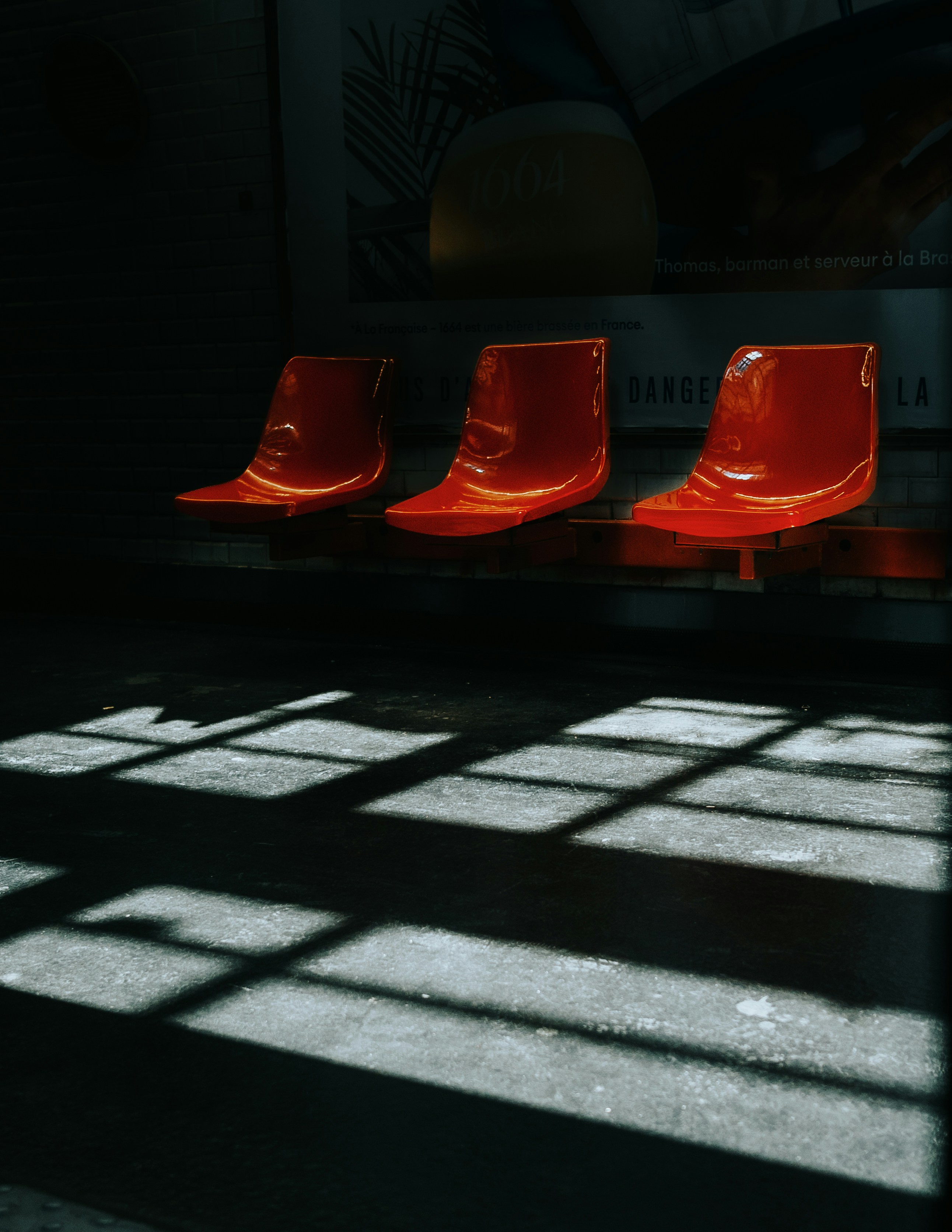 Row of Scarlet Seats in a Shadowed Station Nook