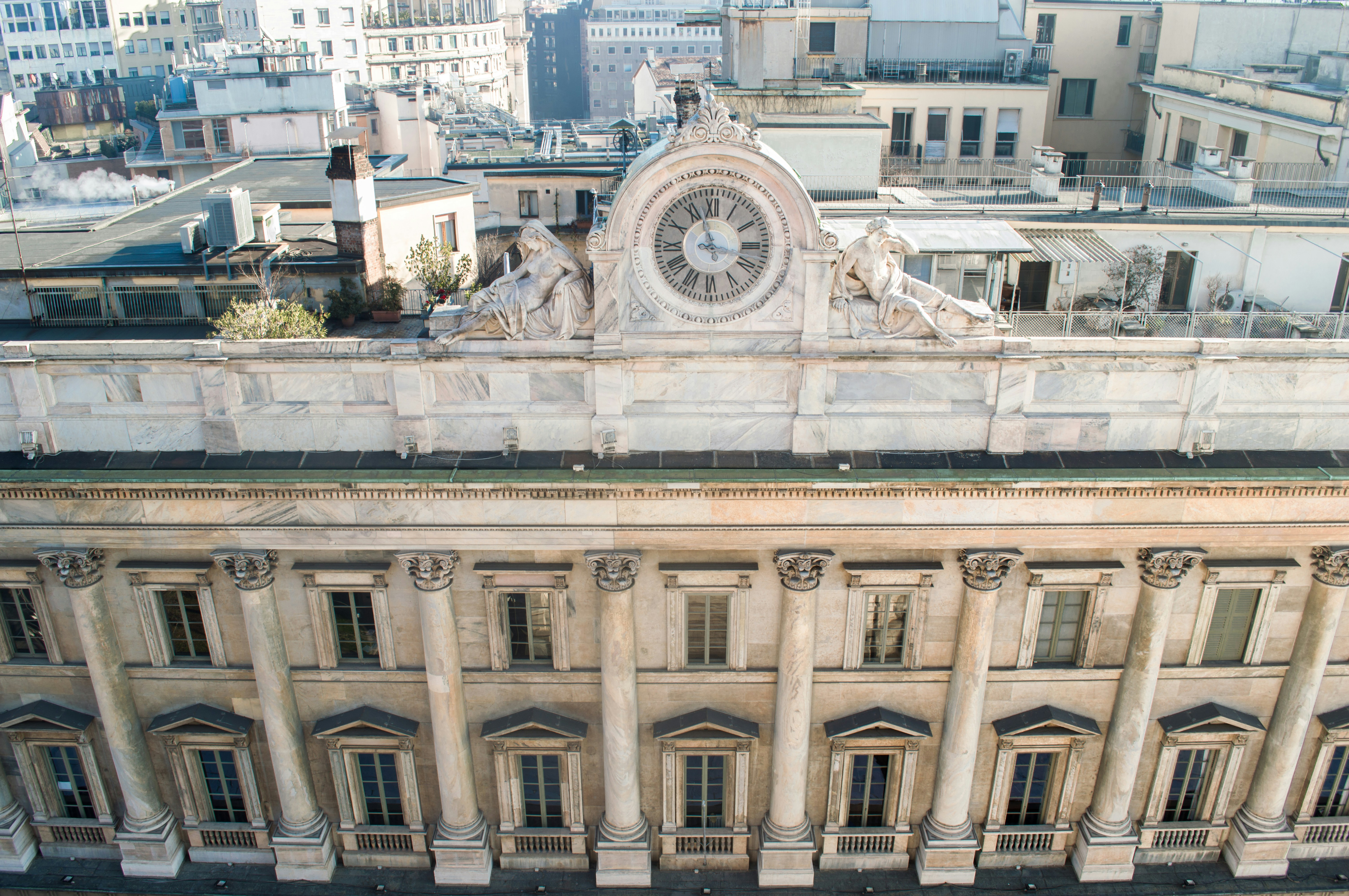 Clocked Facade: Neoclassical Courtyard Rooftop View Framed by Timeless Columns