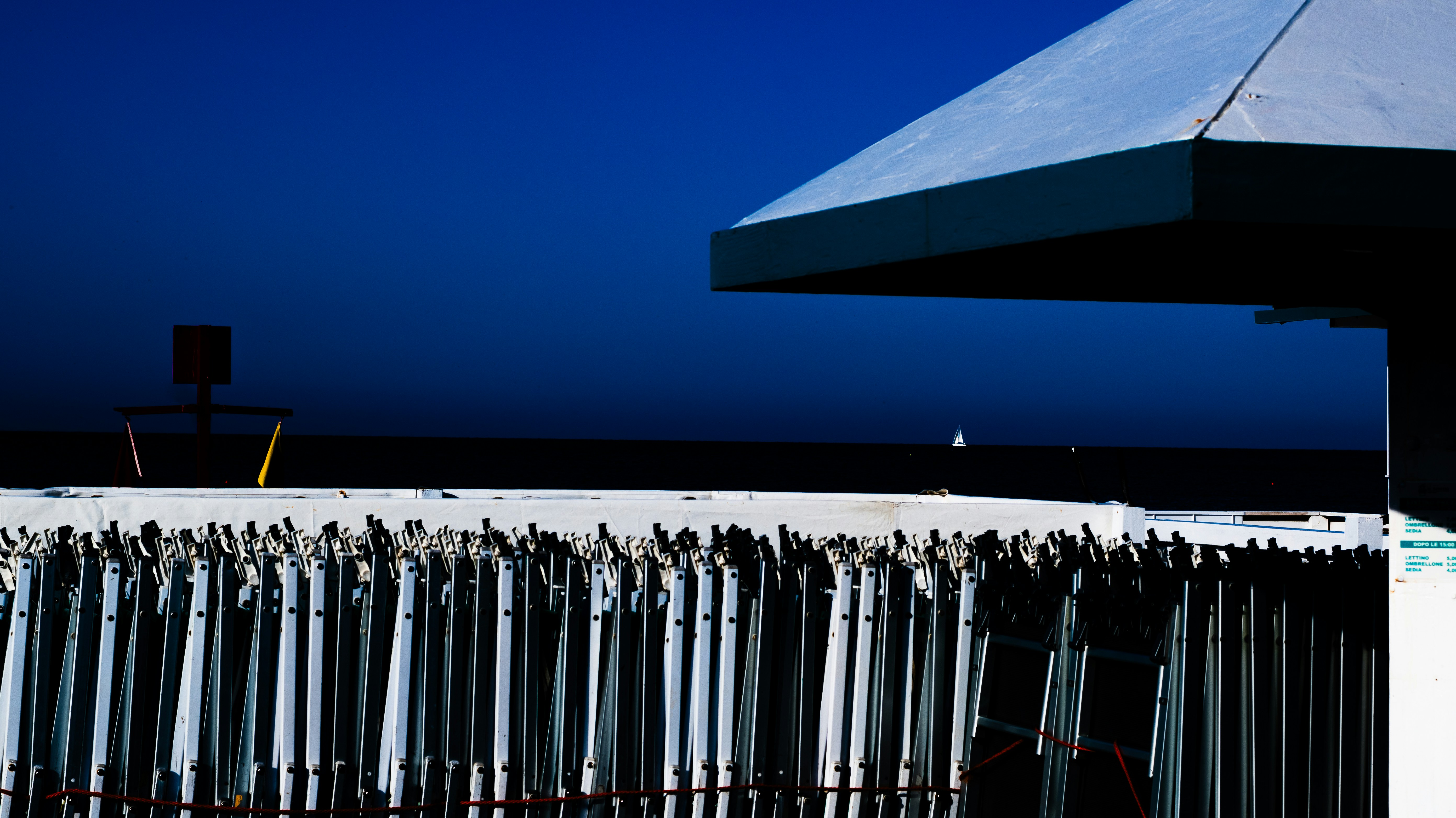 Blue Hour Lines: White Poles March Along a Quiet Seaside Promenade