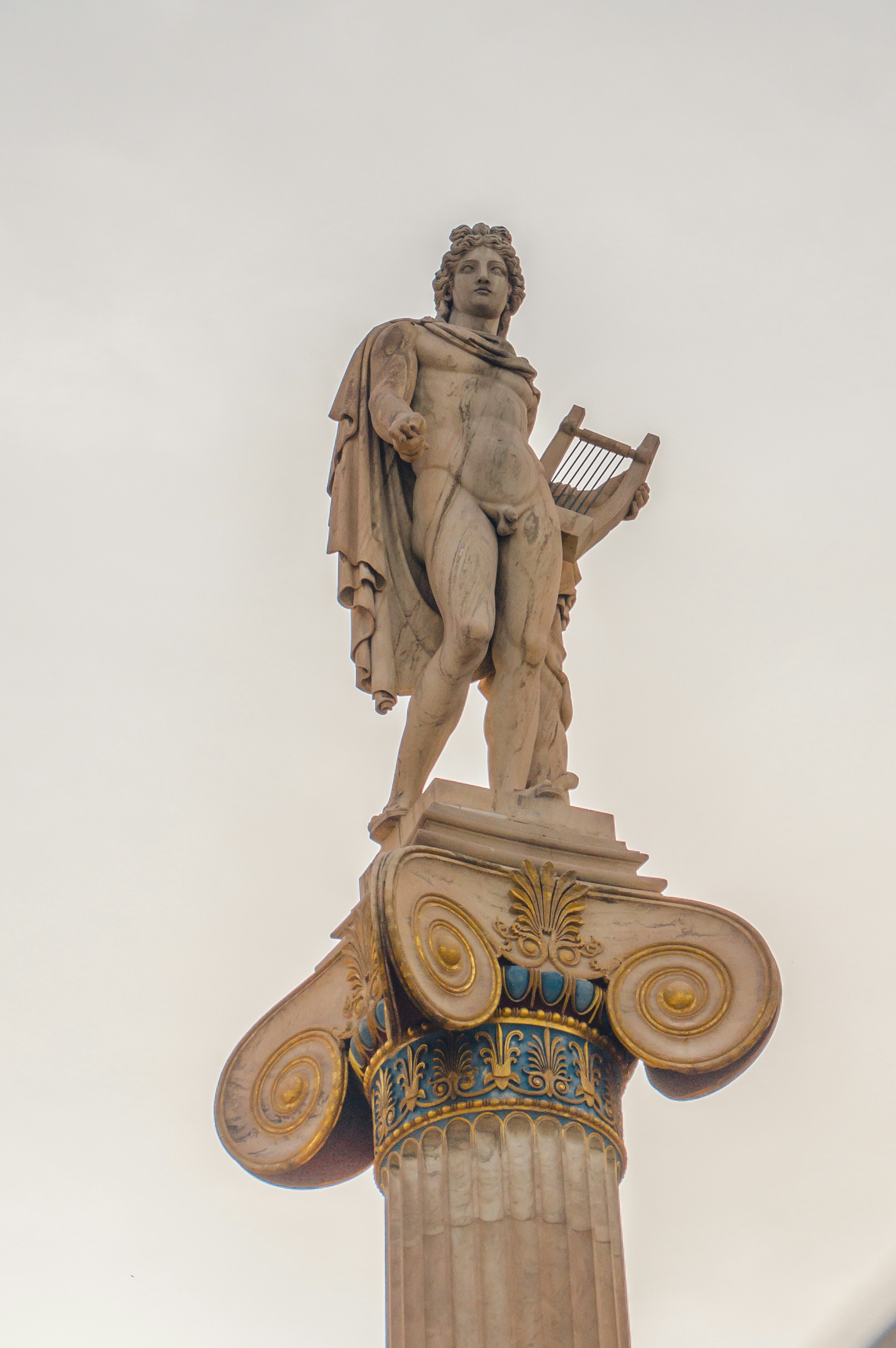 A statue of apollo stands atop a column. photo – Free Art Image on Unsplash