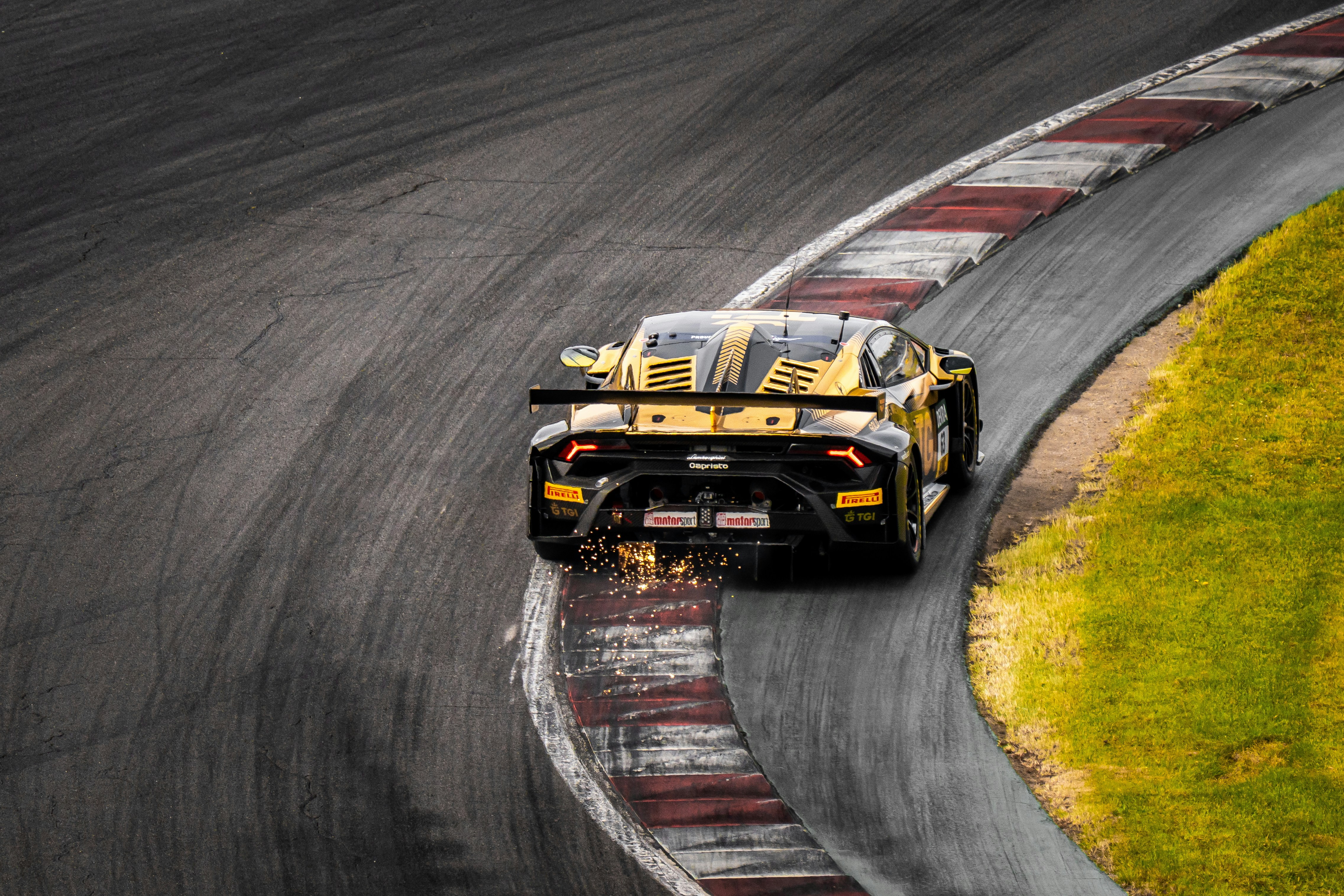 A yellow race car speeds around a track. photo – Free Car Image on Unsplash
