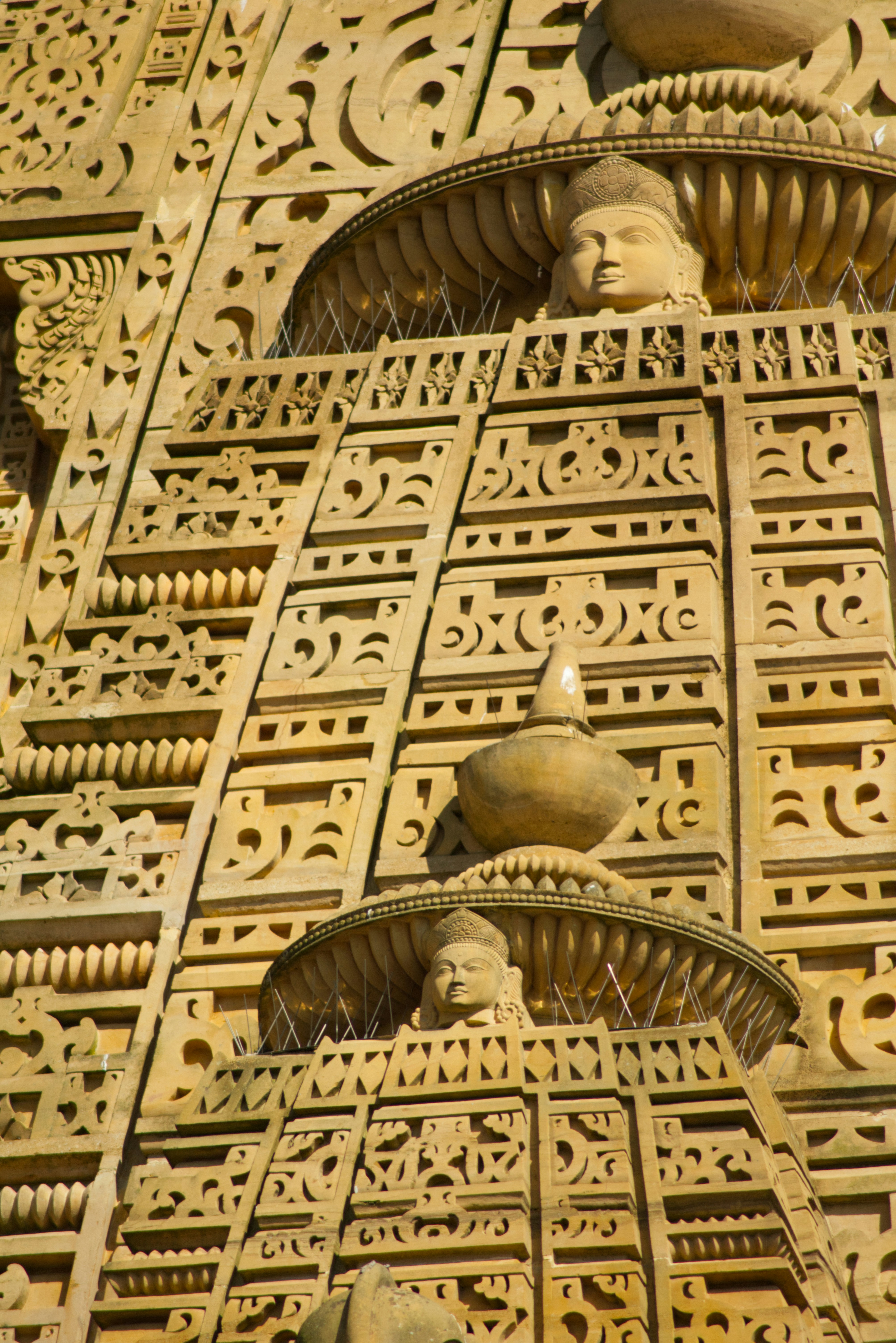 Detailed architectural design featuring ornate carvings and serene figures, showcasing craftsmanship and cultural significance.